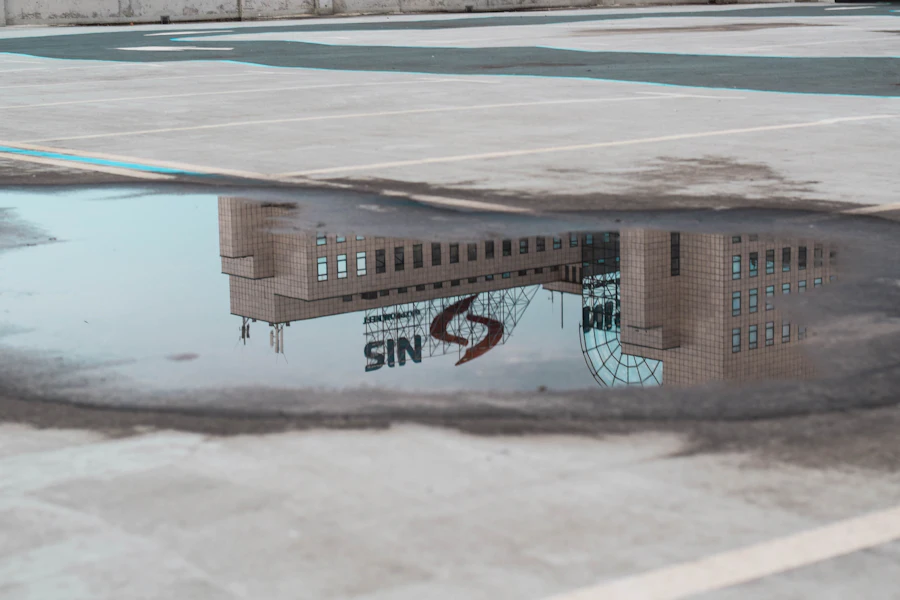 Reflection of a modern building in a puddle on a parking lot surface, capturing the essence of urban life and architecture.