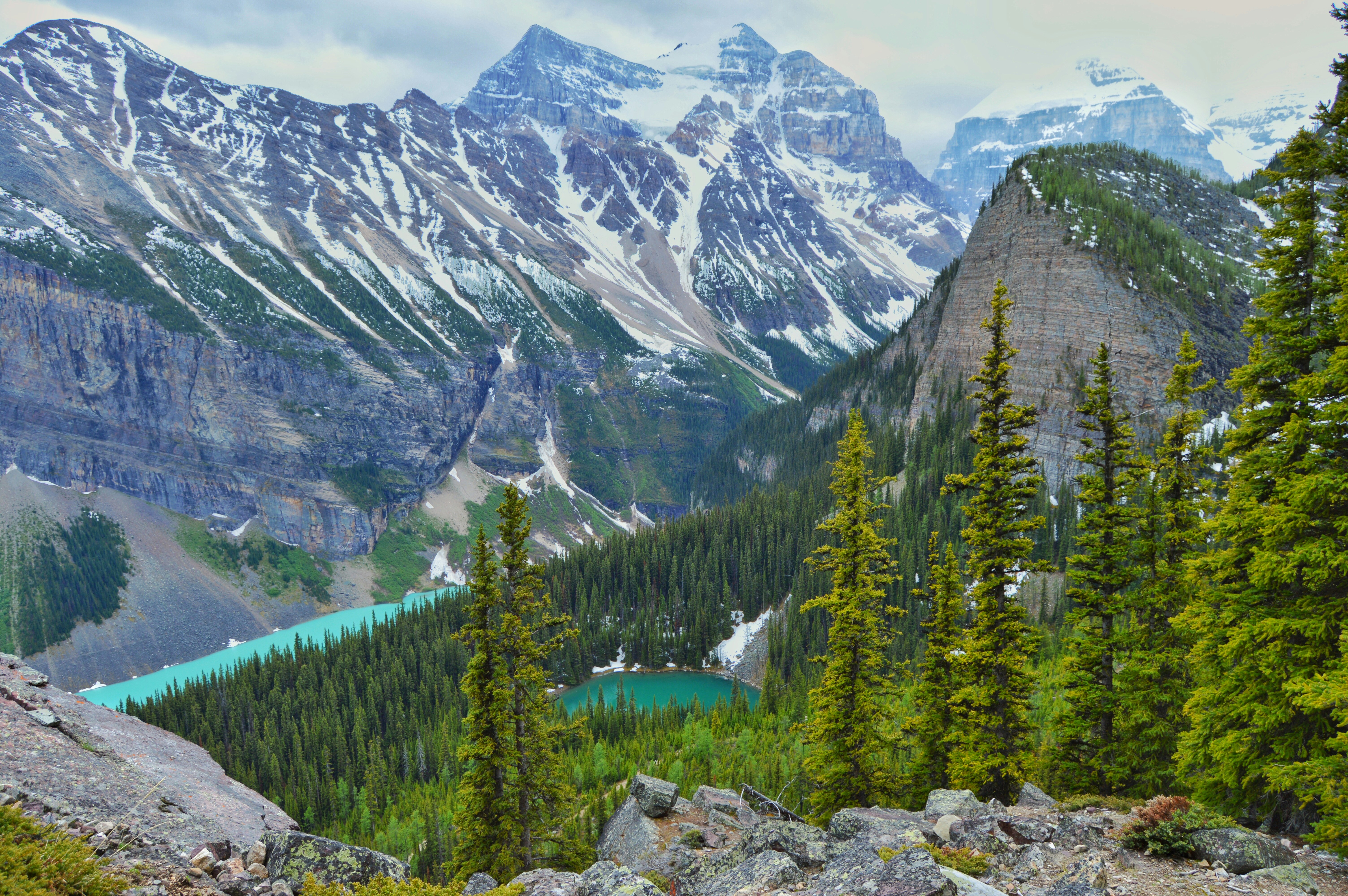 Mirror Lake and Lake Louise nestled among towering snow-capped mountains and lush forests.