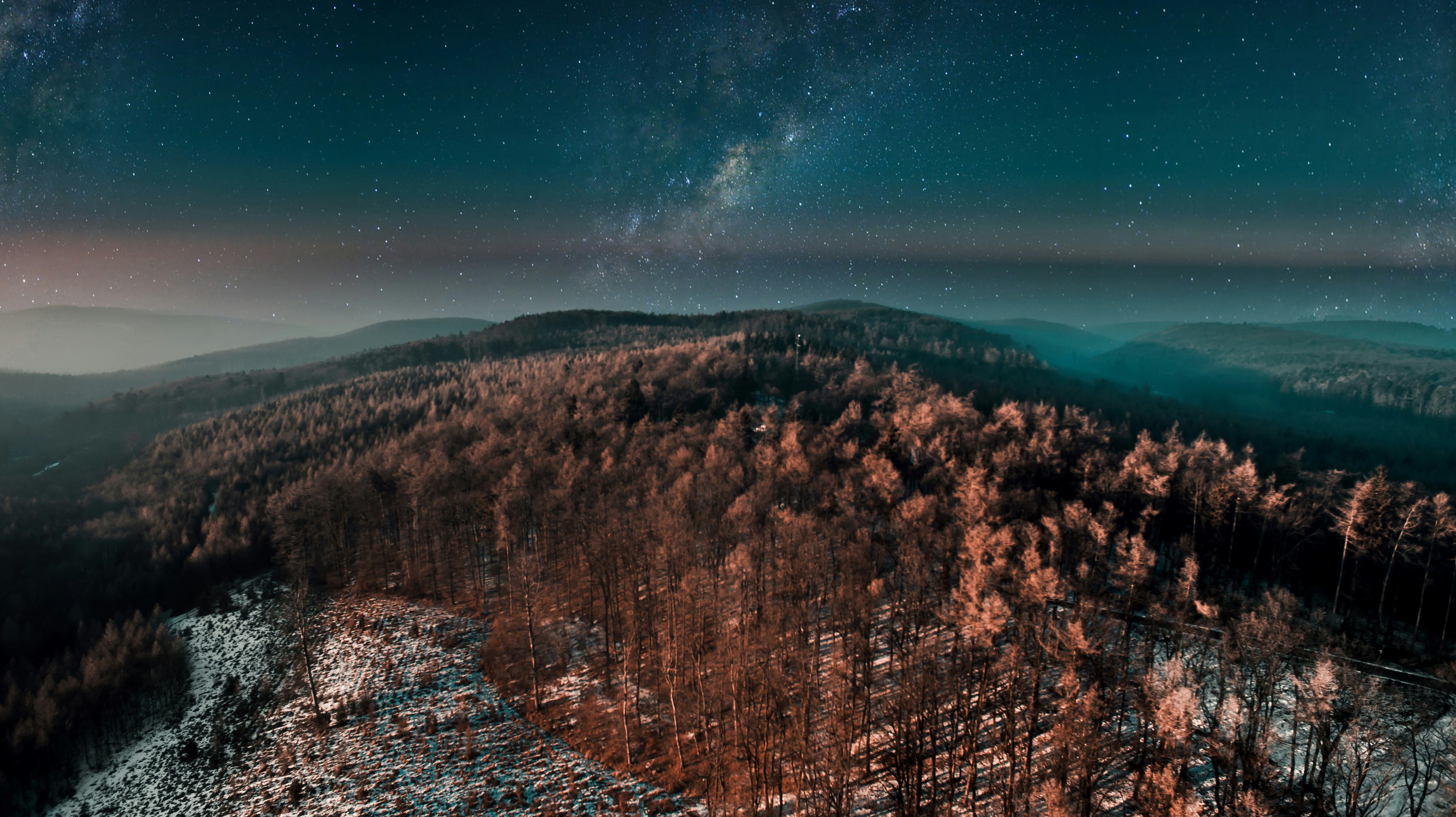 Starbound Ridge: Milky Way Over a Red-Tinted Forest