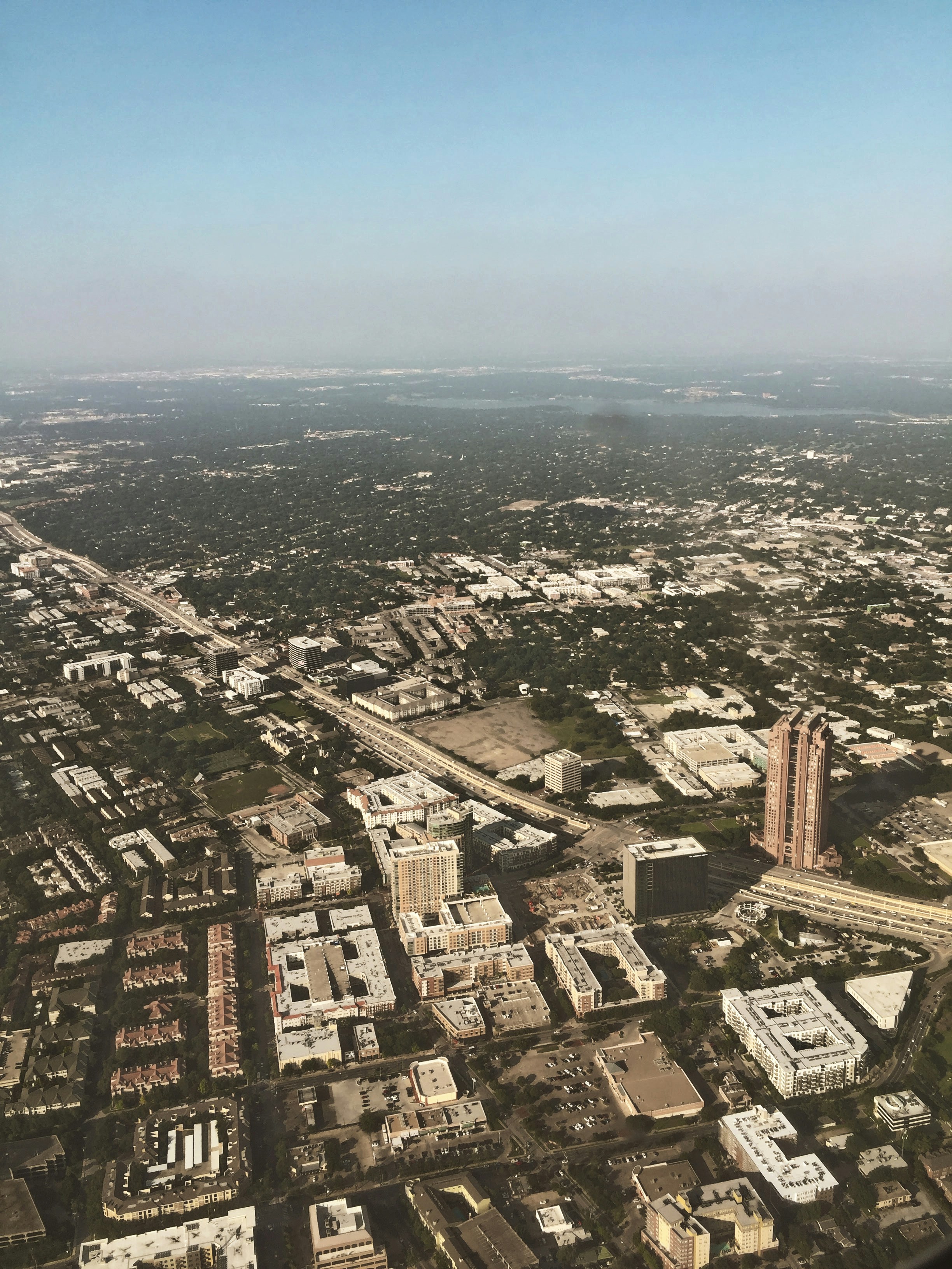 Aerial view showcasing a sprawling urban landscape with a mix of buildings, roads, and green spaces, highlighting the intricate layout of the city.