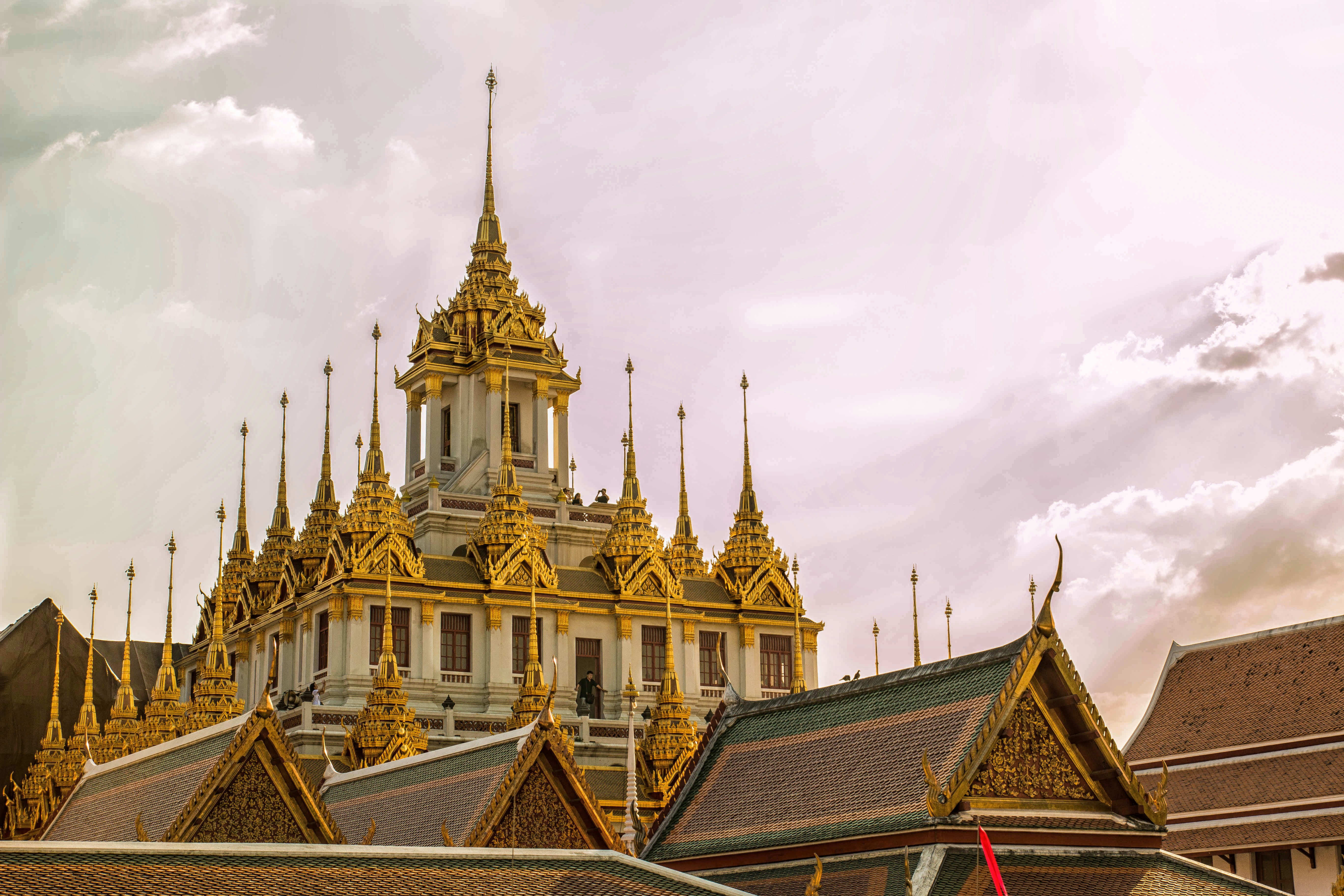Ornate temple with golden spires against a cloudy sky.