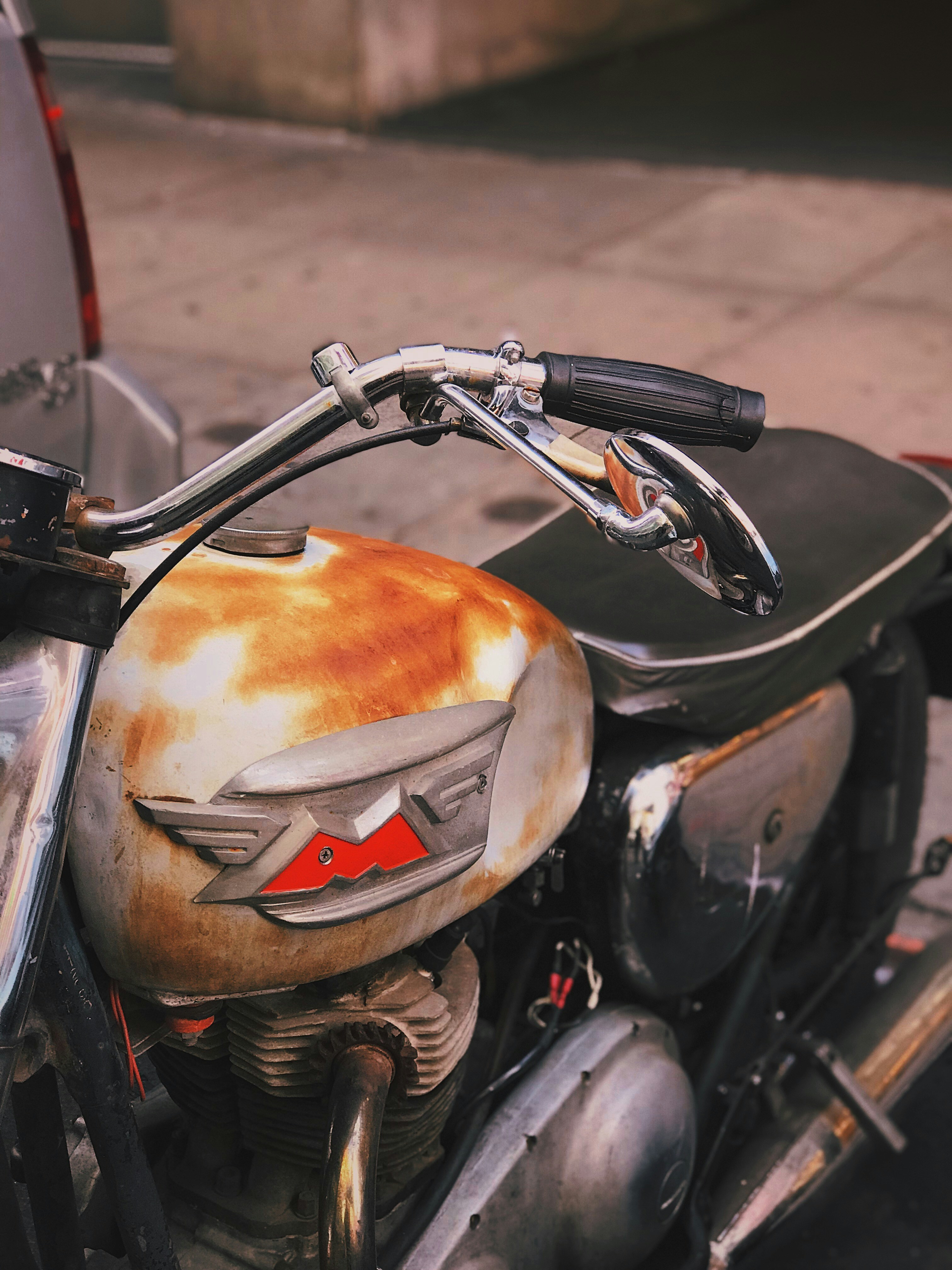 Patinaed Ironhorse: Close-Up on a Weathered Vintage Motorcycle Tank