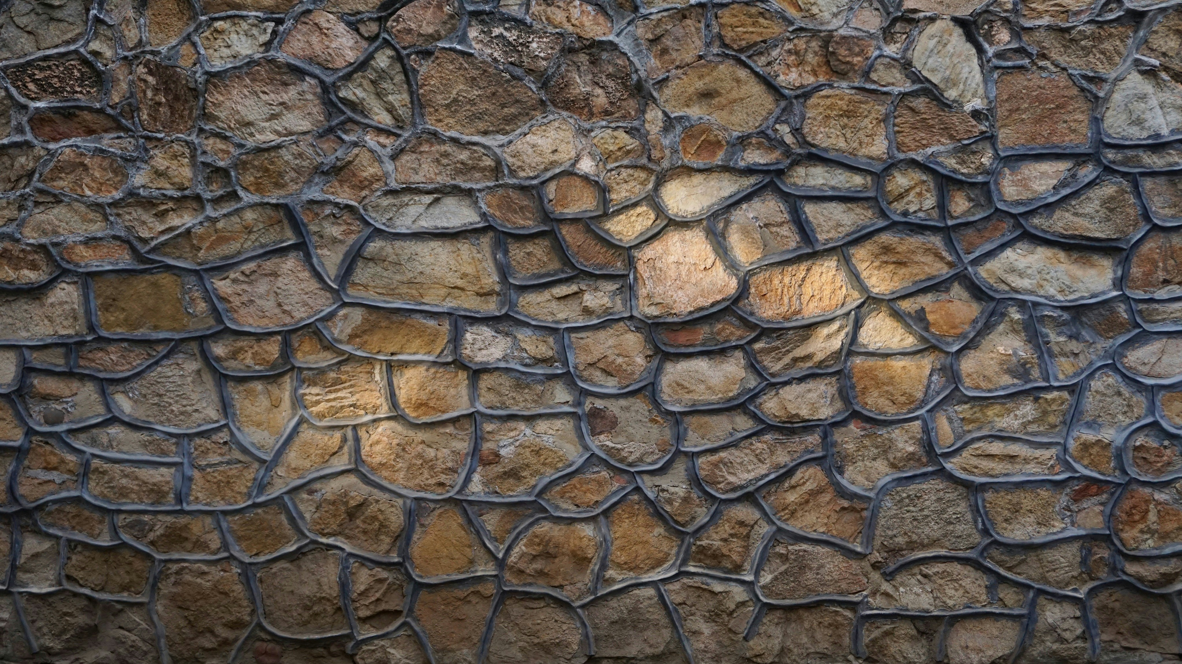 Intricate stone wall showcasing a mosaic of earthy tones and textures, emphasizing the natural beauty of the materials.