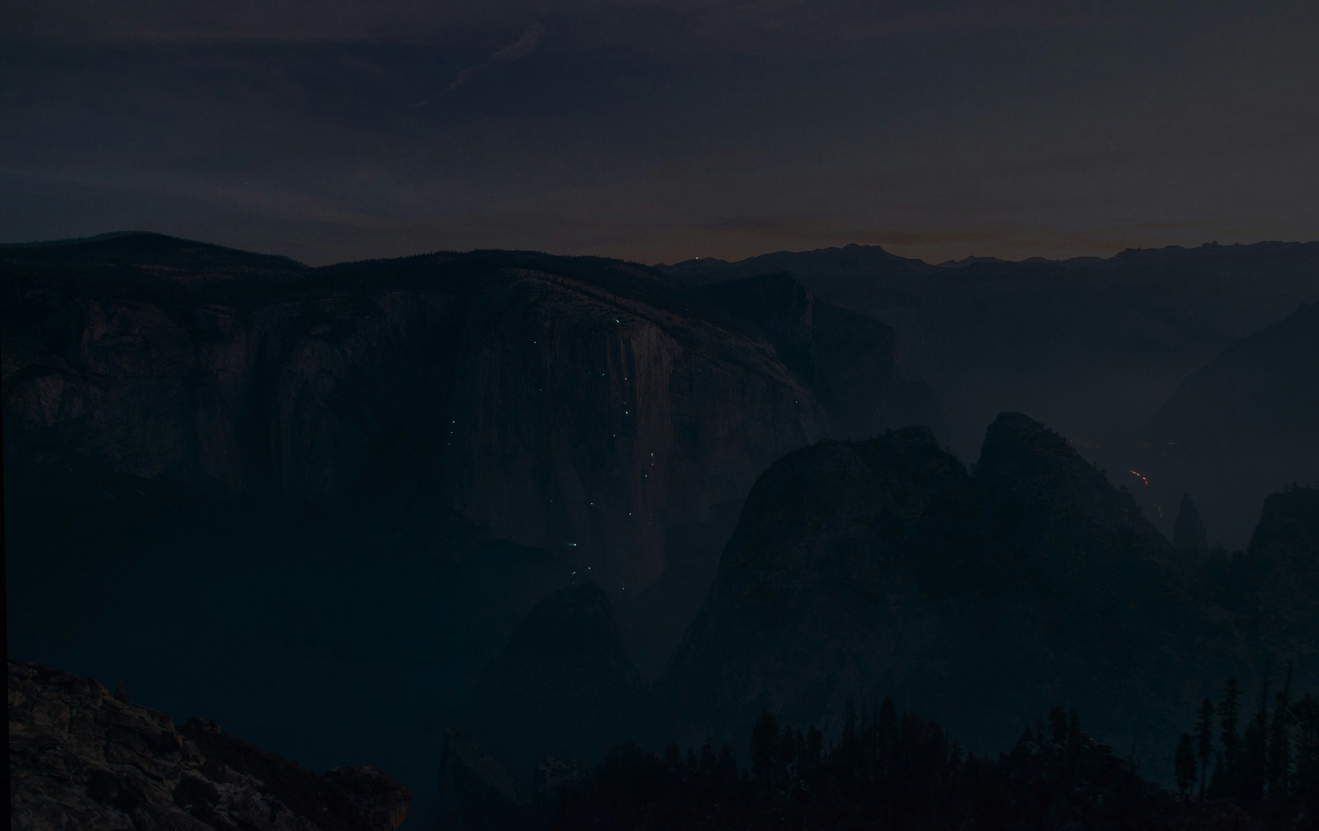 Nightfall Over Jagged Cliffs: A Distant Cascade of Lights