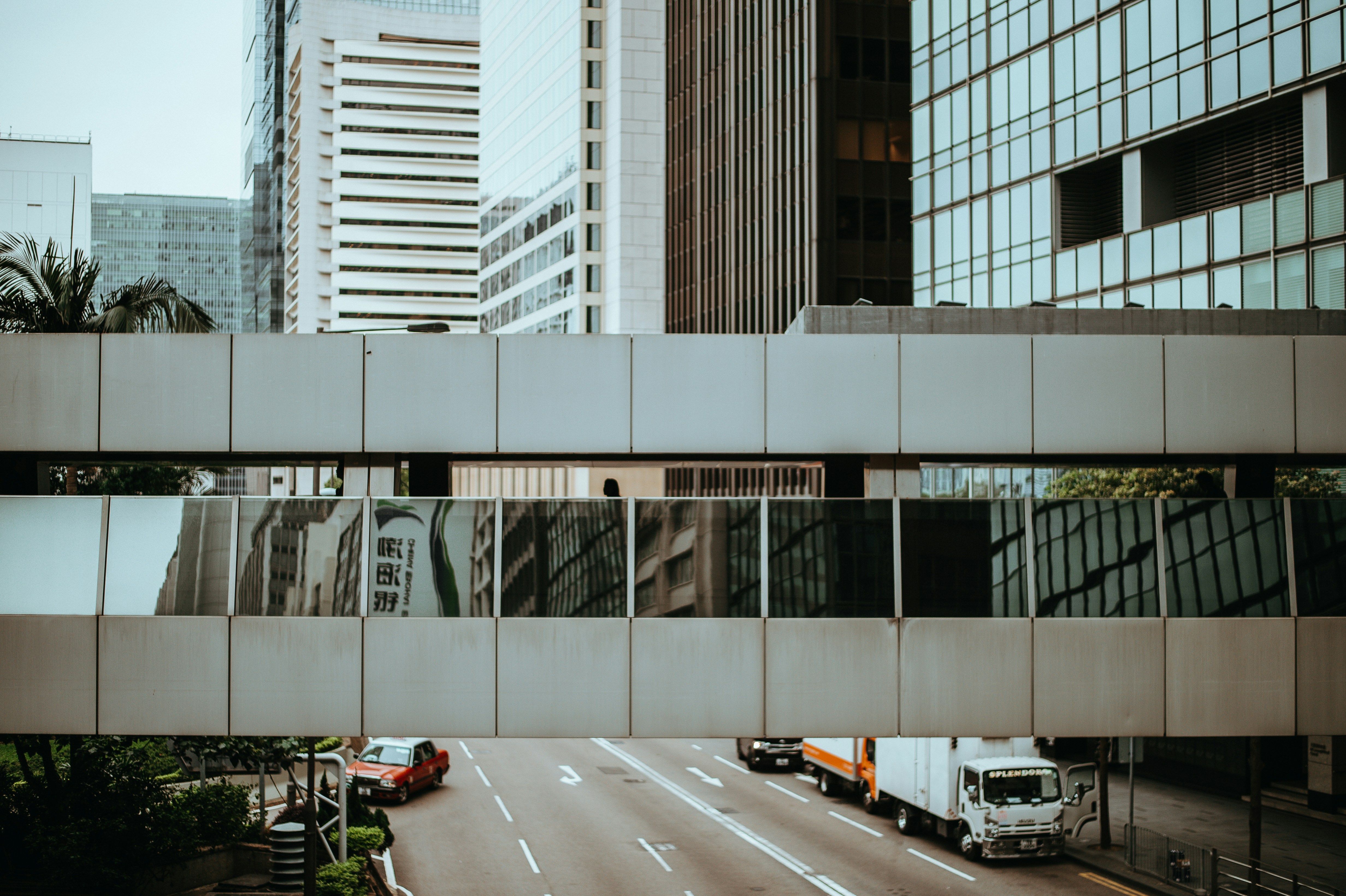 Crossing Glass: City Skybridge Framed by Reflections