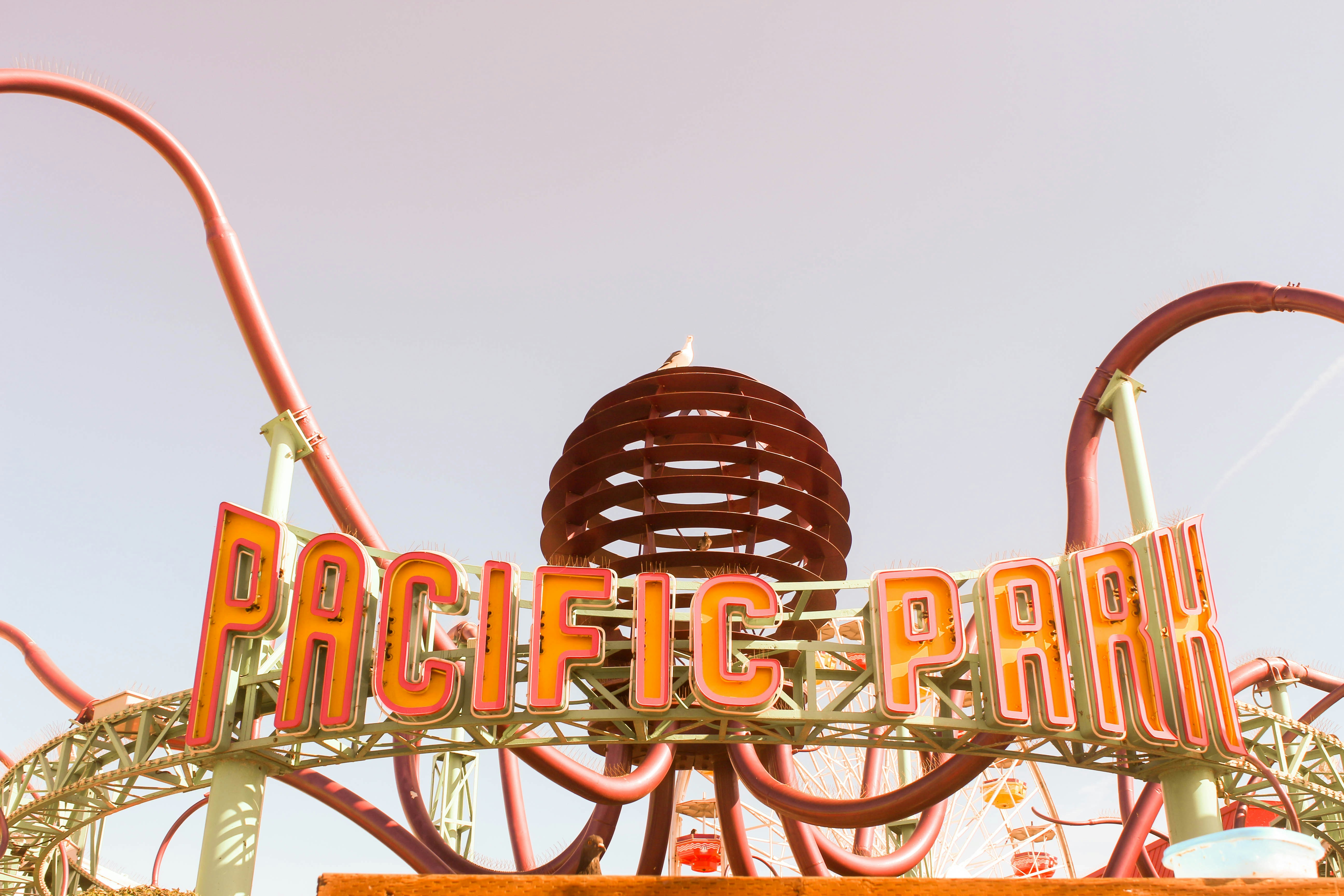 Pastel Sunset Crowns Pacific Park's Neon Sign Over a Coaster Loop