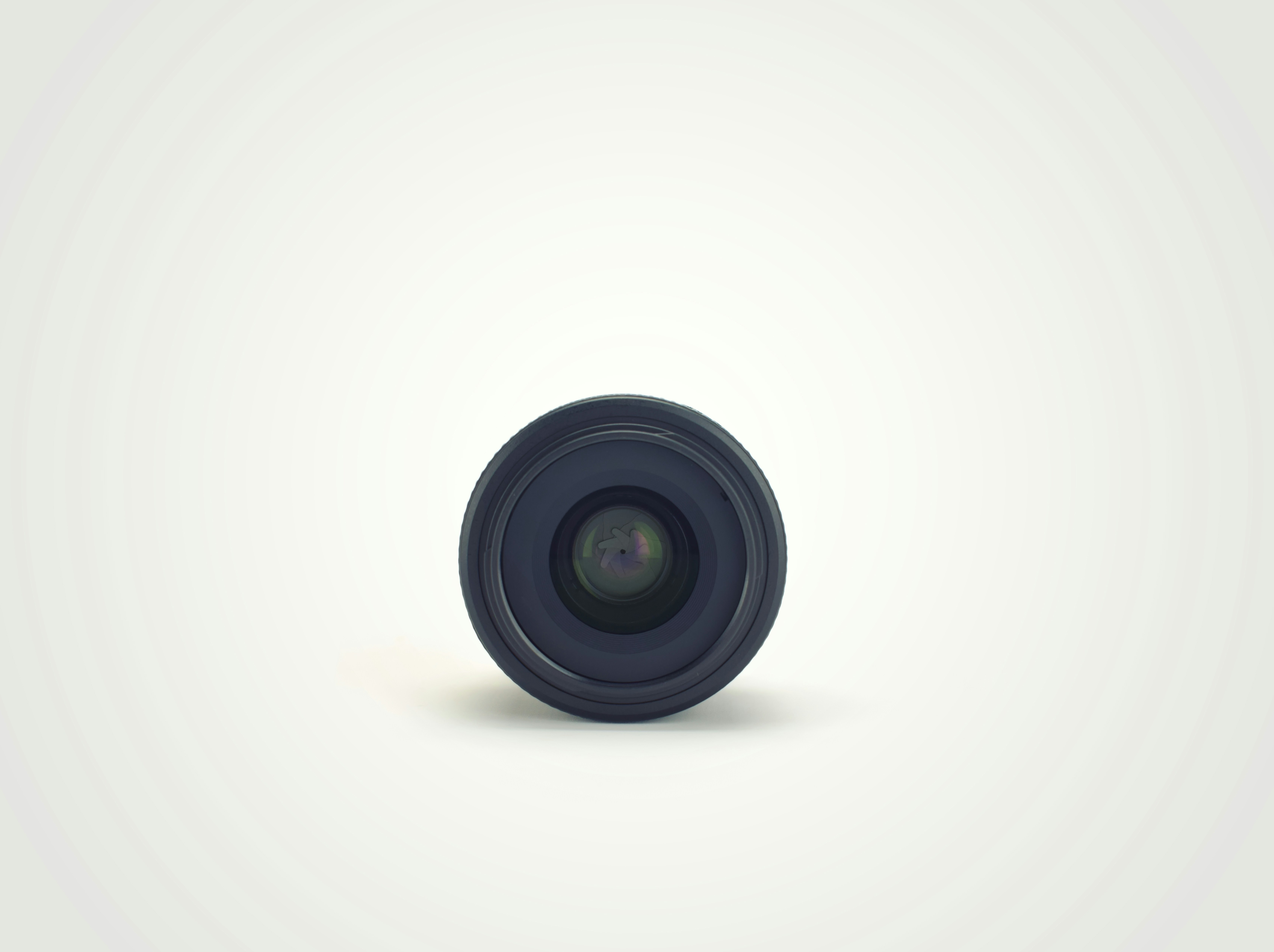 Center-aligned camera lens against a soft gradient background.