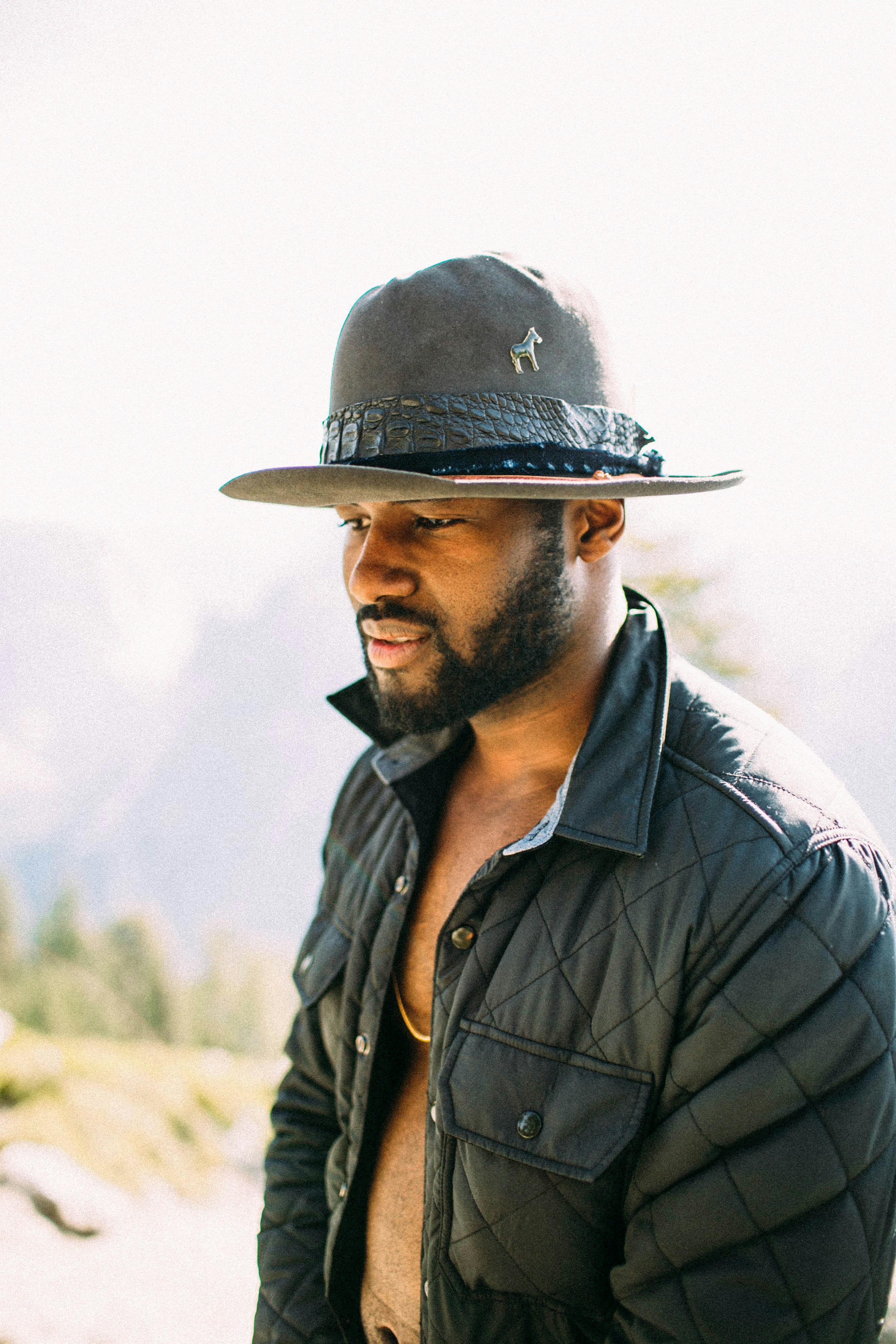 Man wearing cowboy hat and buffer jacket looking down outdoor photo ...