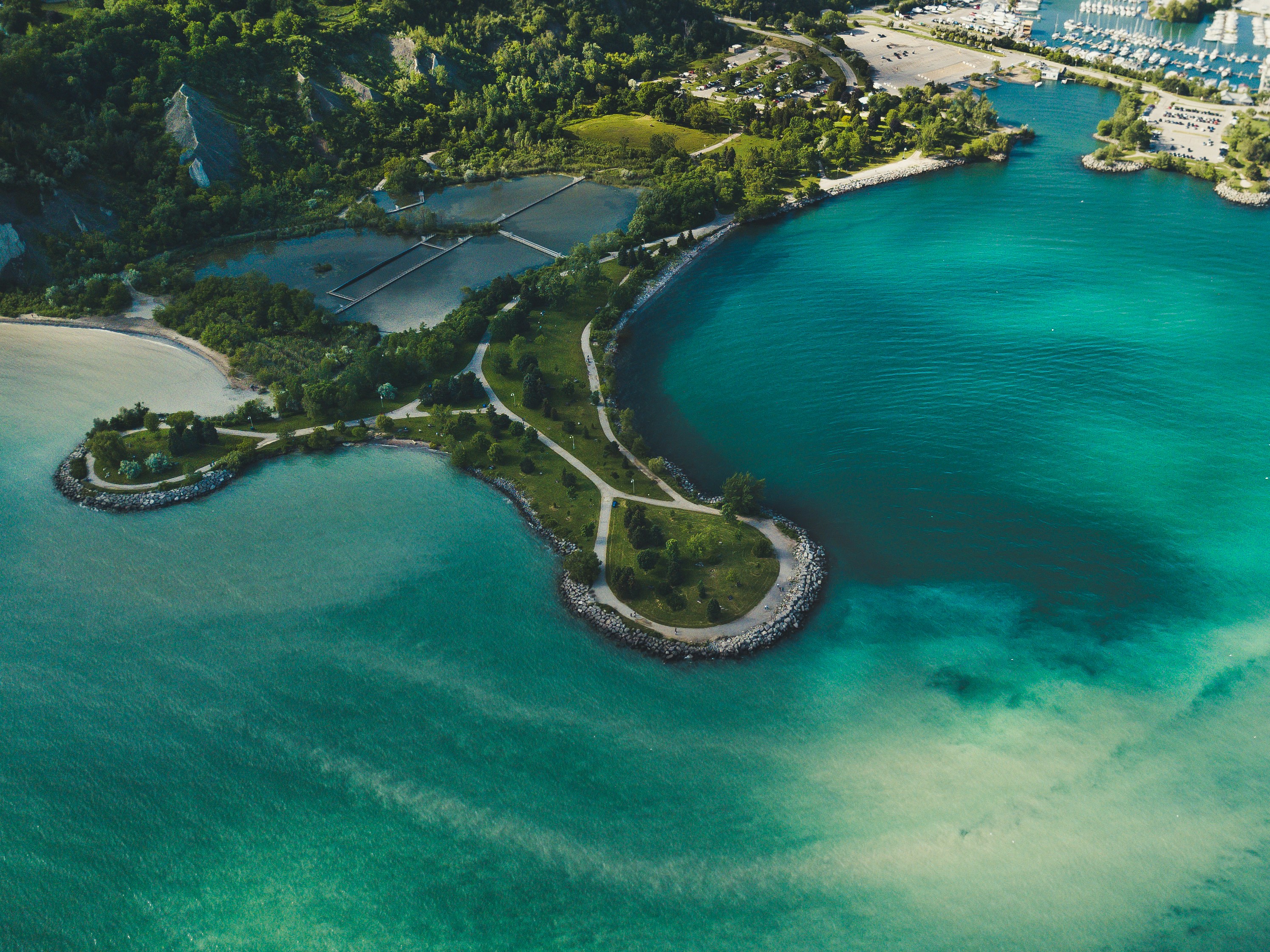 Aerial view of a lush green peninsula encircled by vibrant turquoise waters.