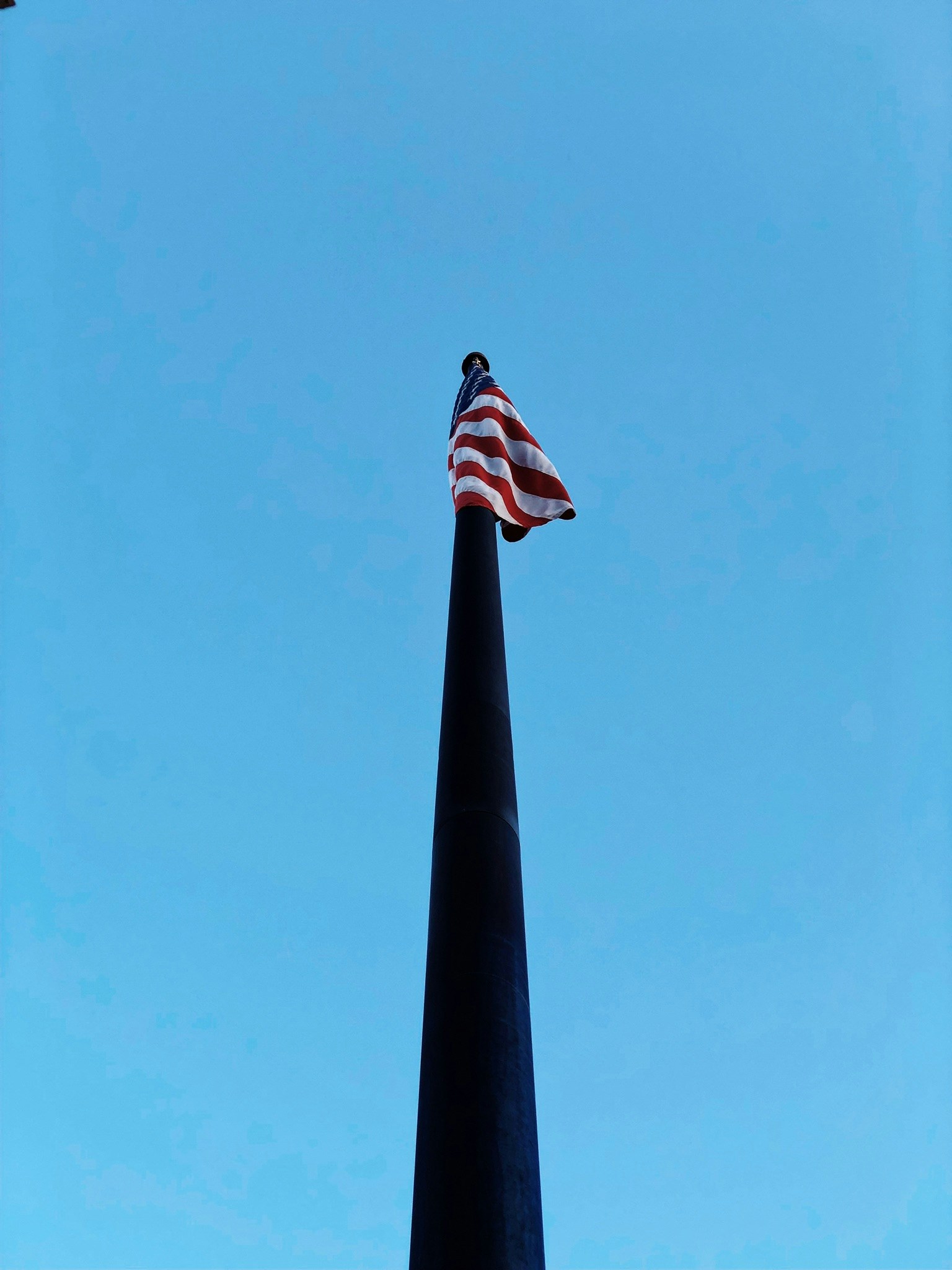 Flag at the Peak under a Pristine Blue Sky