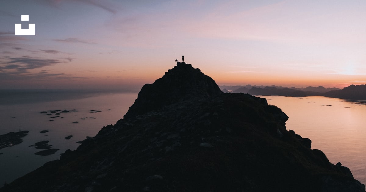 Silueta En Persona De Pie En El Acantilado Superior De La Montaña Foto