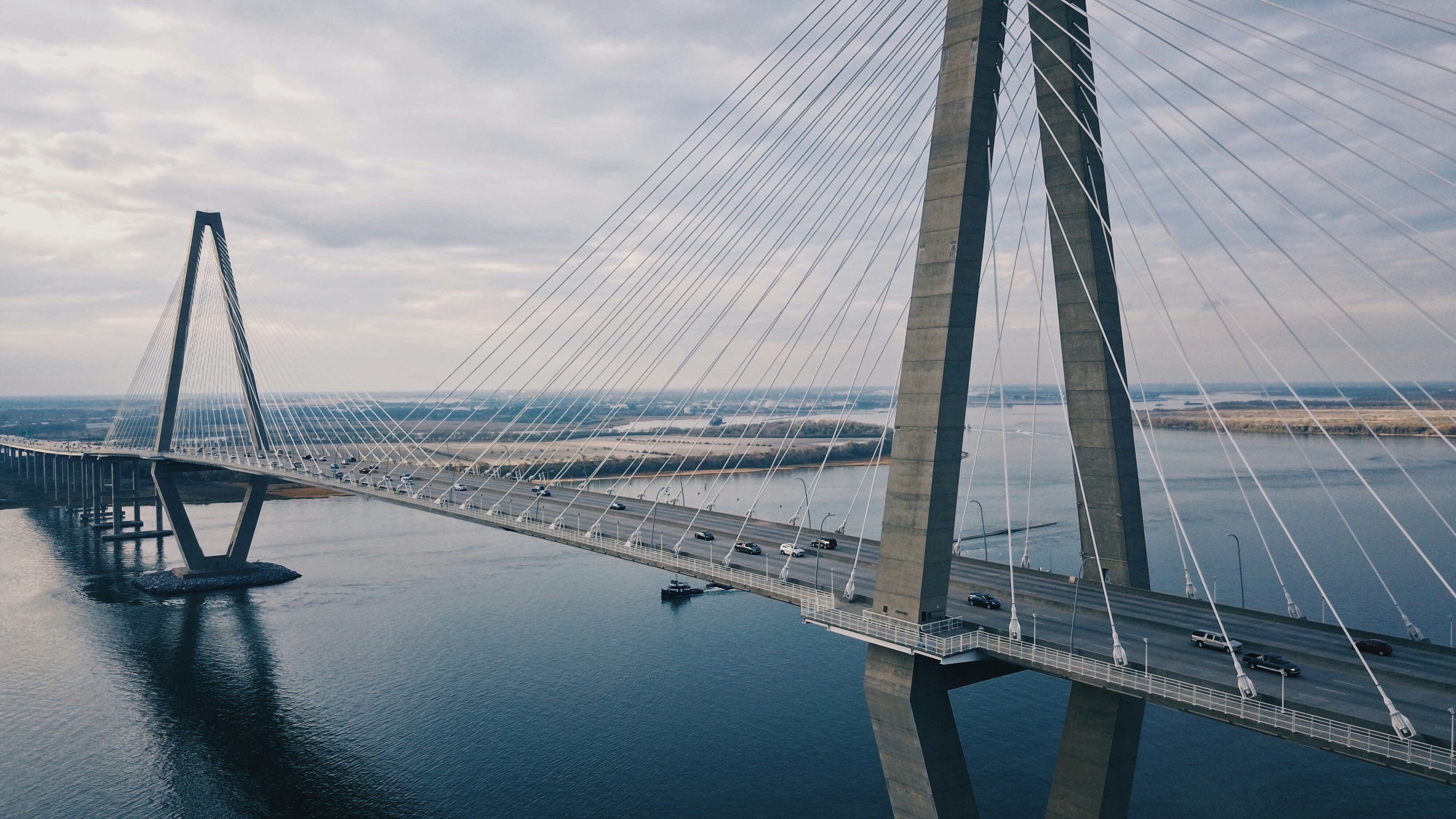 This is one of my favorite architectural structures in Charleston, SC. I shot this with a DJI Mavic Pro drone and edited it in VSCO. I took the shot at approximately 4:00p and the weather was slightly overcast. | gray suspension bridge