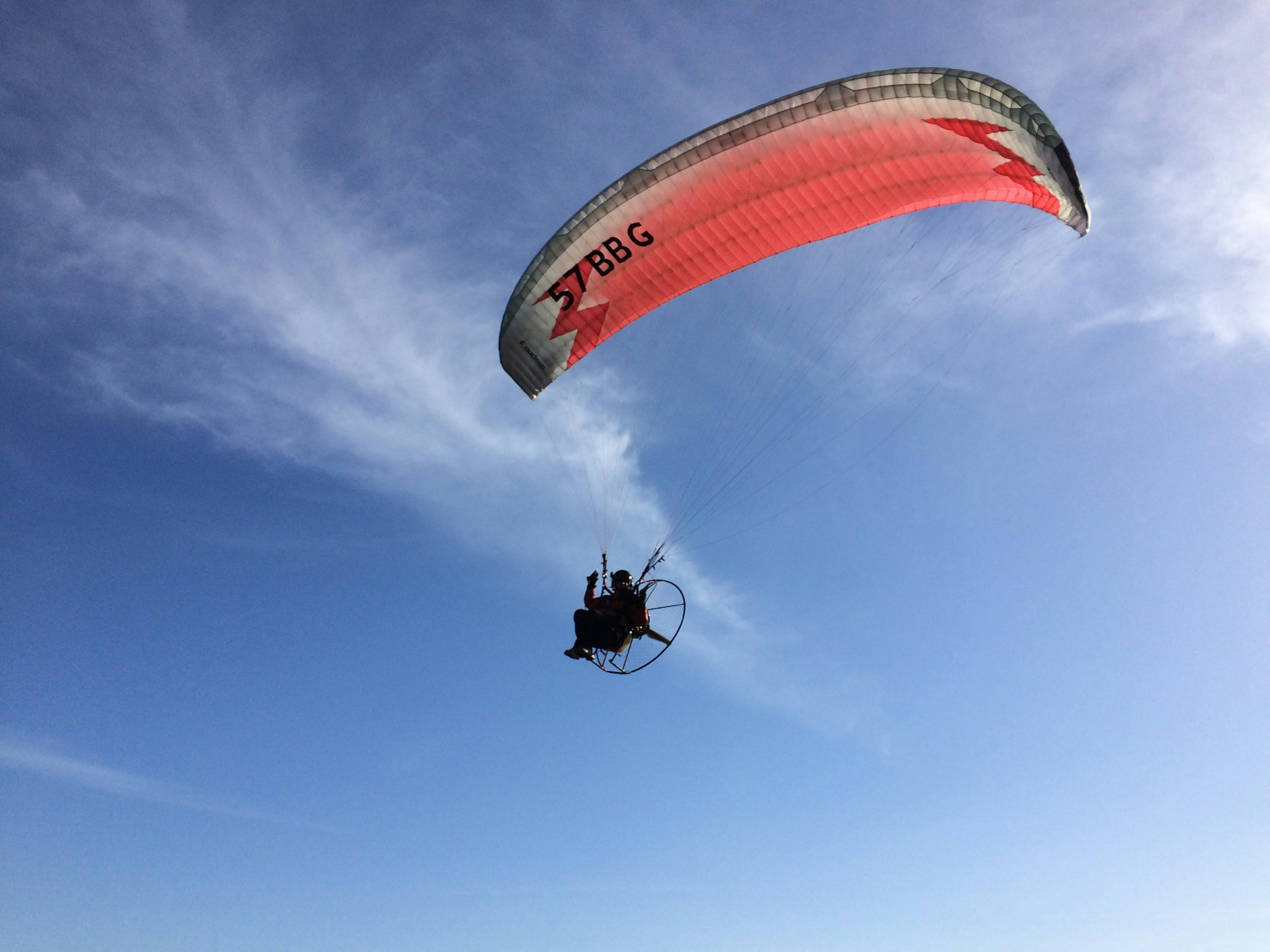 Crimson Wing over a Sapphire Sky: A Solo Paraglider Moment