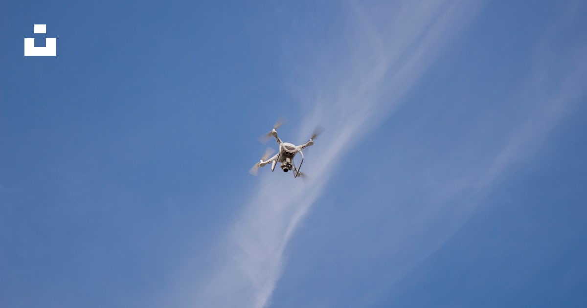昼間に空飛ぶ白いクワッドコプタードローンのローアングル撮影の写真 Unsplashの青いの無料画像