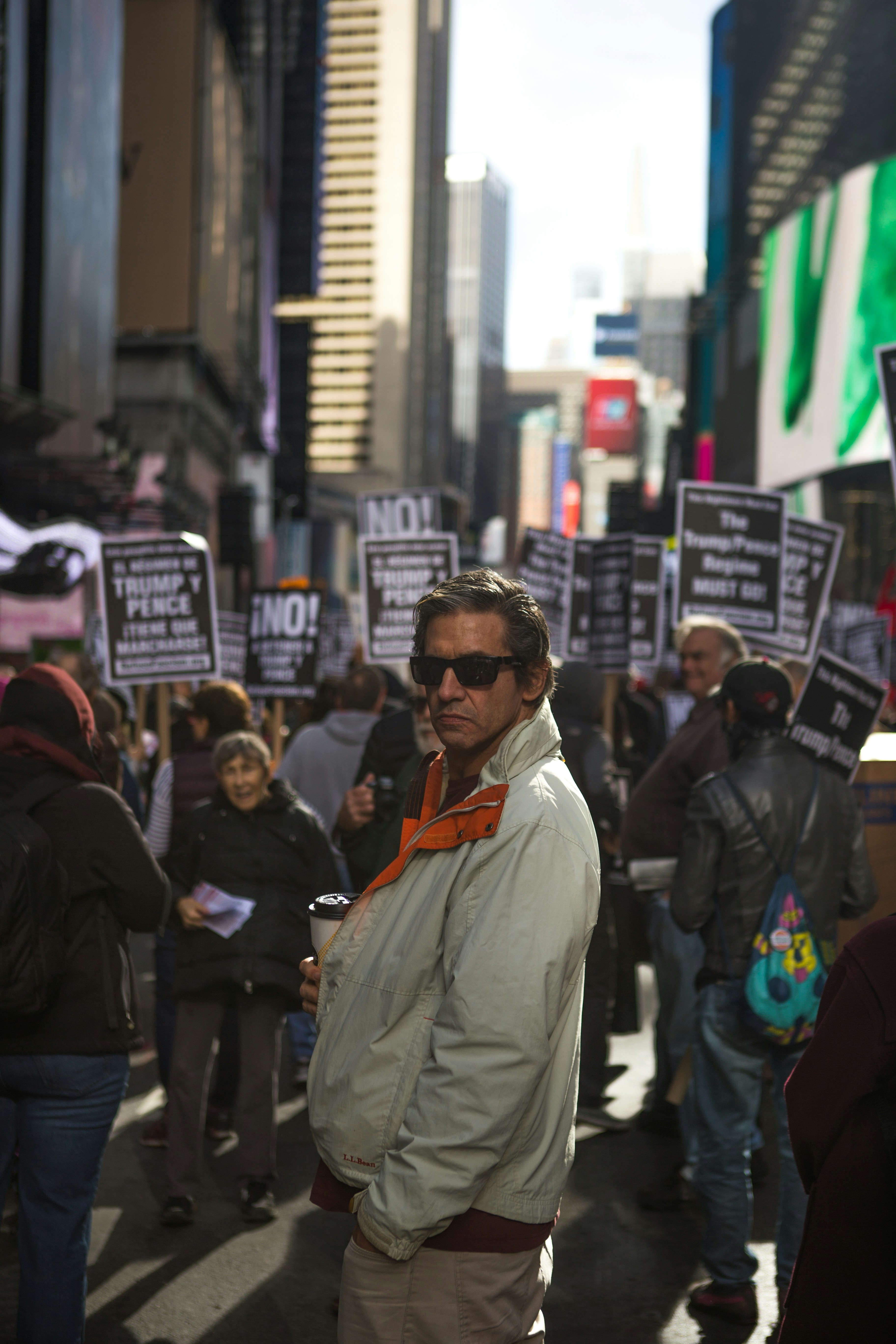 Street Portrait with Reserved Foreground Presence Amid Protest Signs