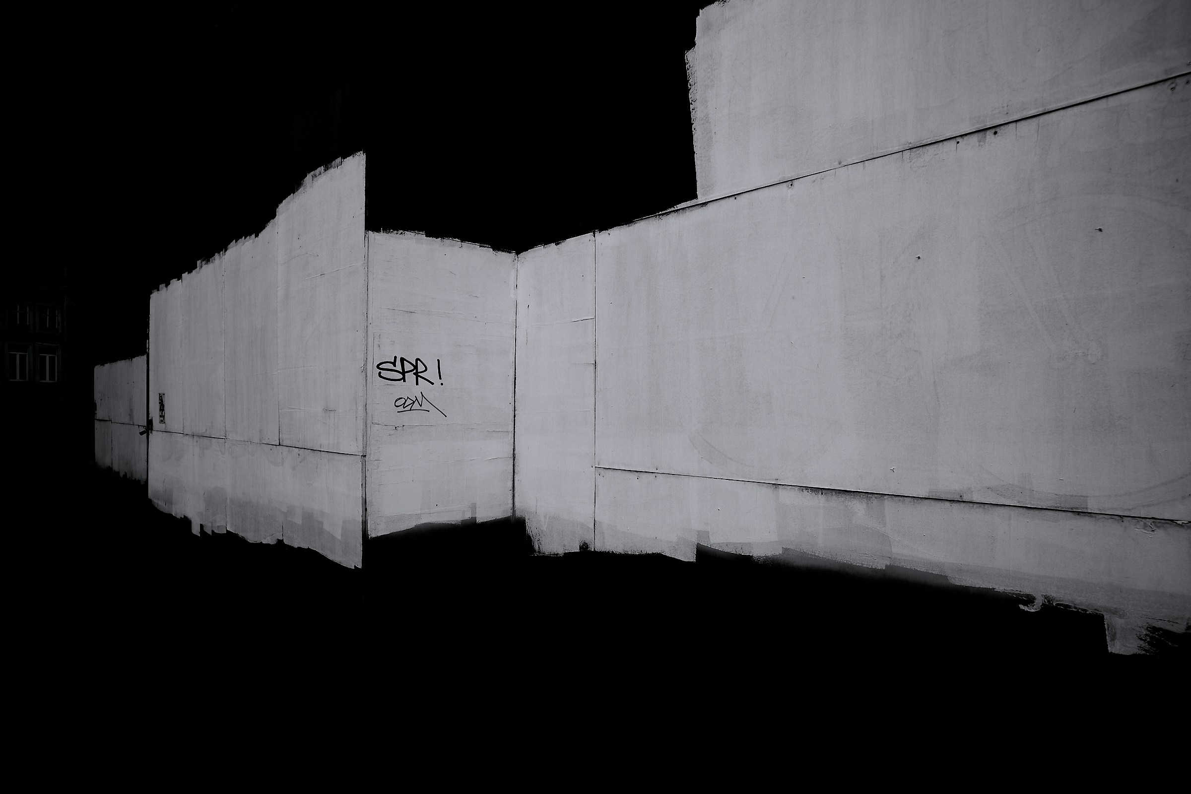 Geometric structures cast stark shadows against a dark backdrop.