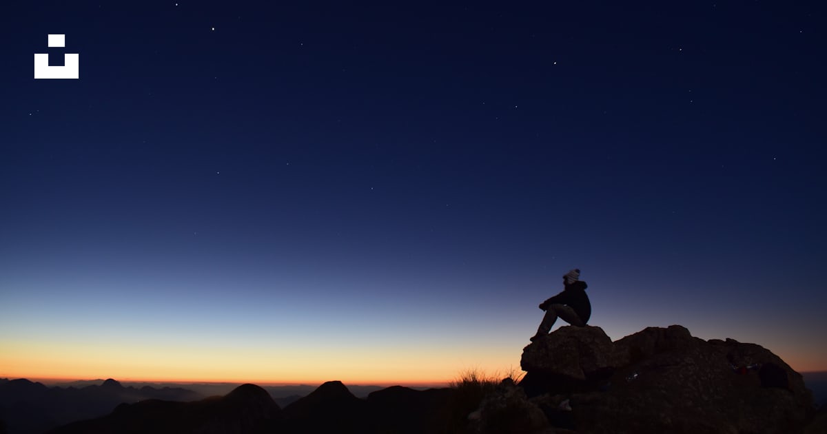 Foto Silueta De La Persona Sentada En La Roca Durante La Noche Imagen