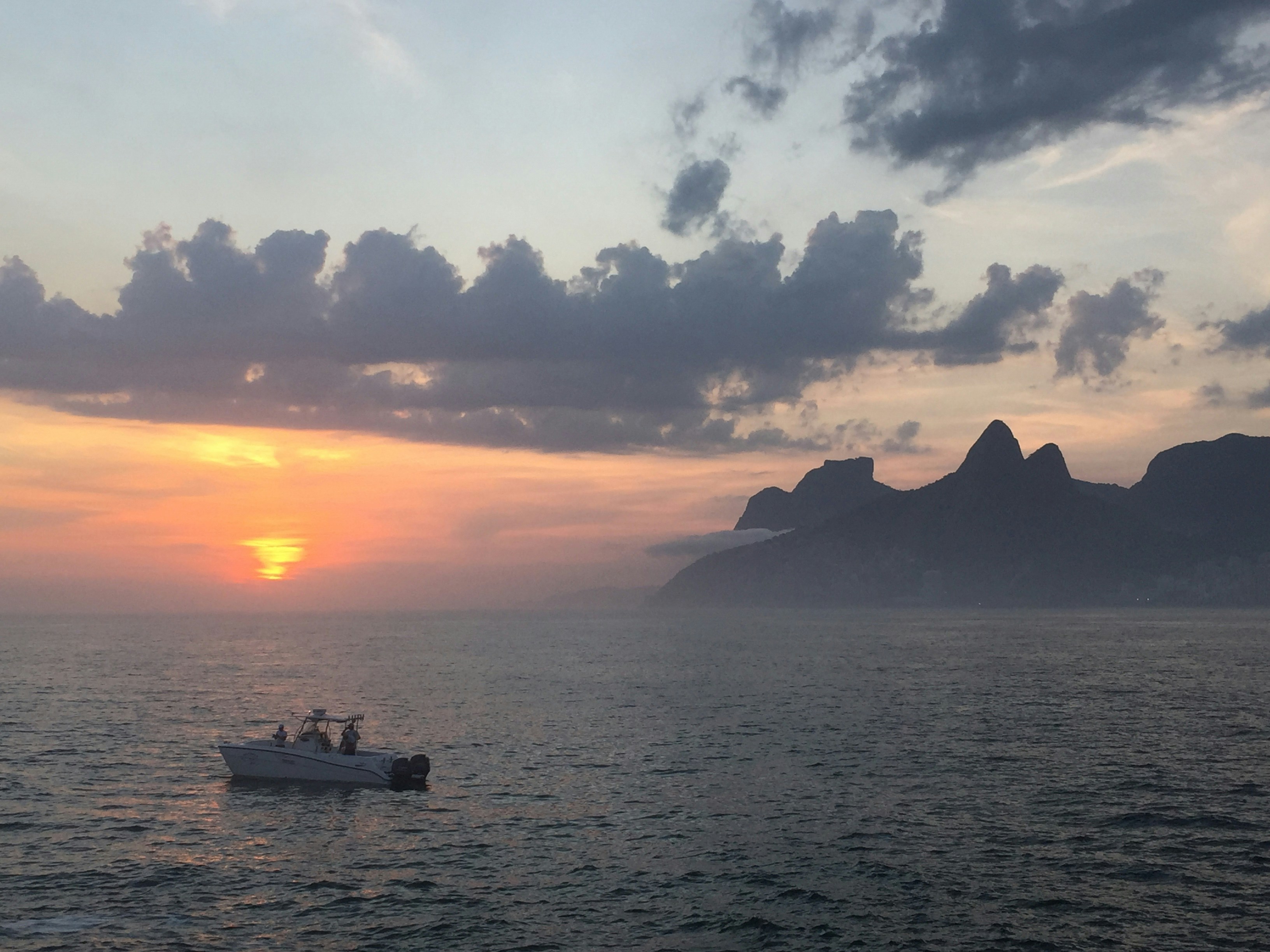 Sunset at the Quiet Sea: A Lone Boat Framing Shadowed Peaks