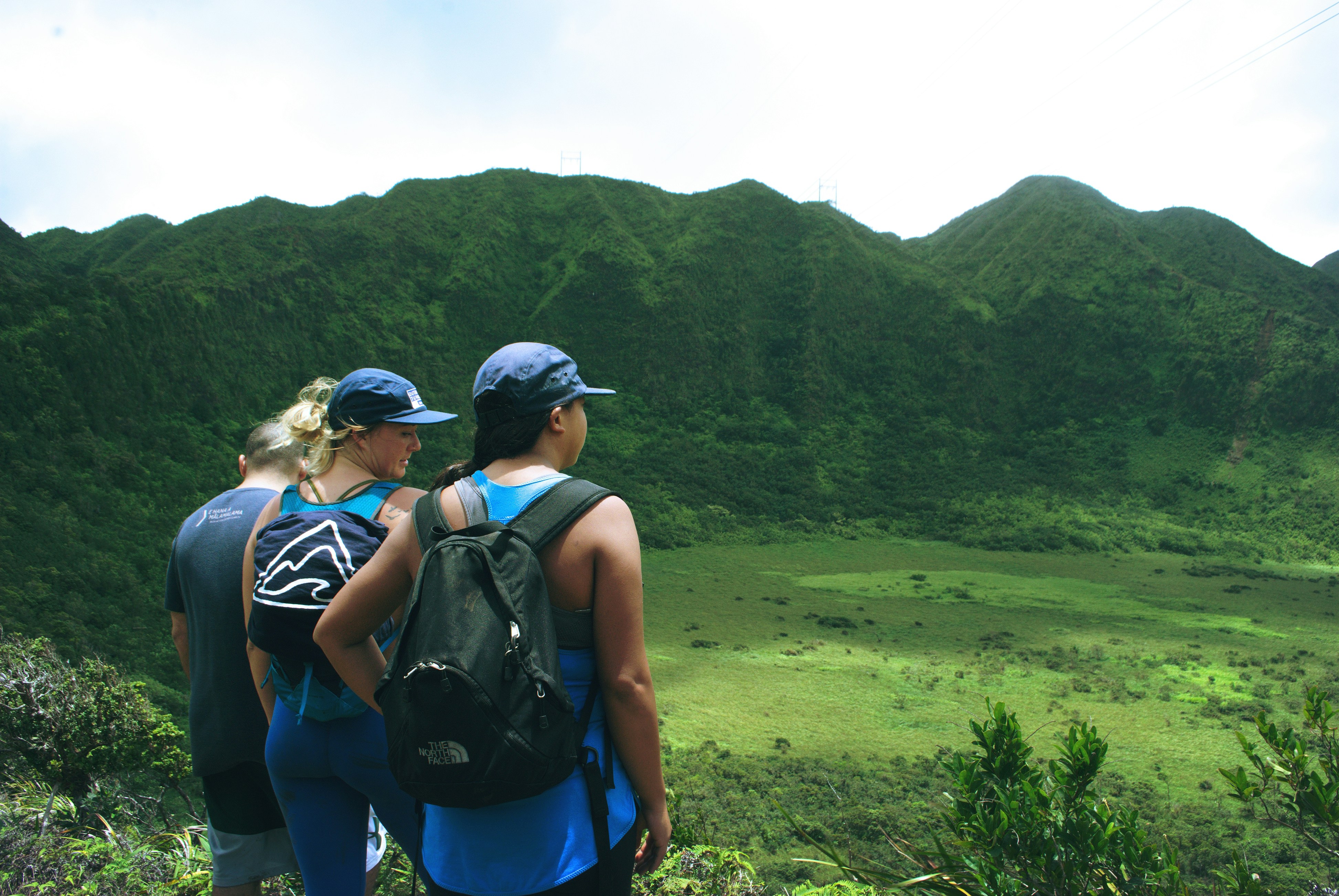 Trio on a Ridge: A Jade Valley Unfolds Beneath Emerald Peaks