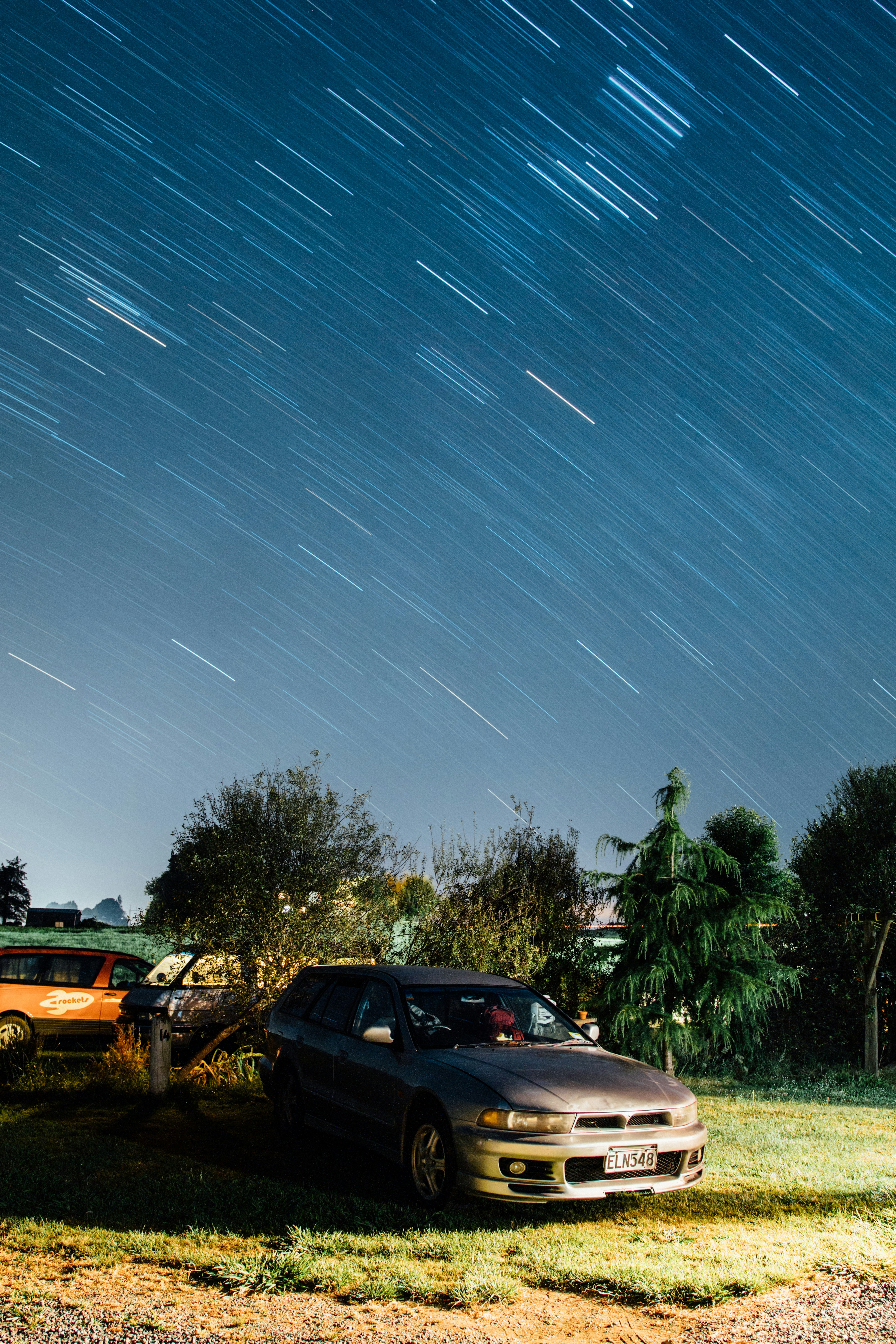 Star Trails Over a Suburban Driveway: A Silver Sedan Beneath the Night Sky