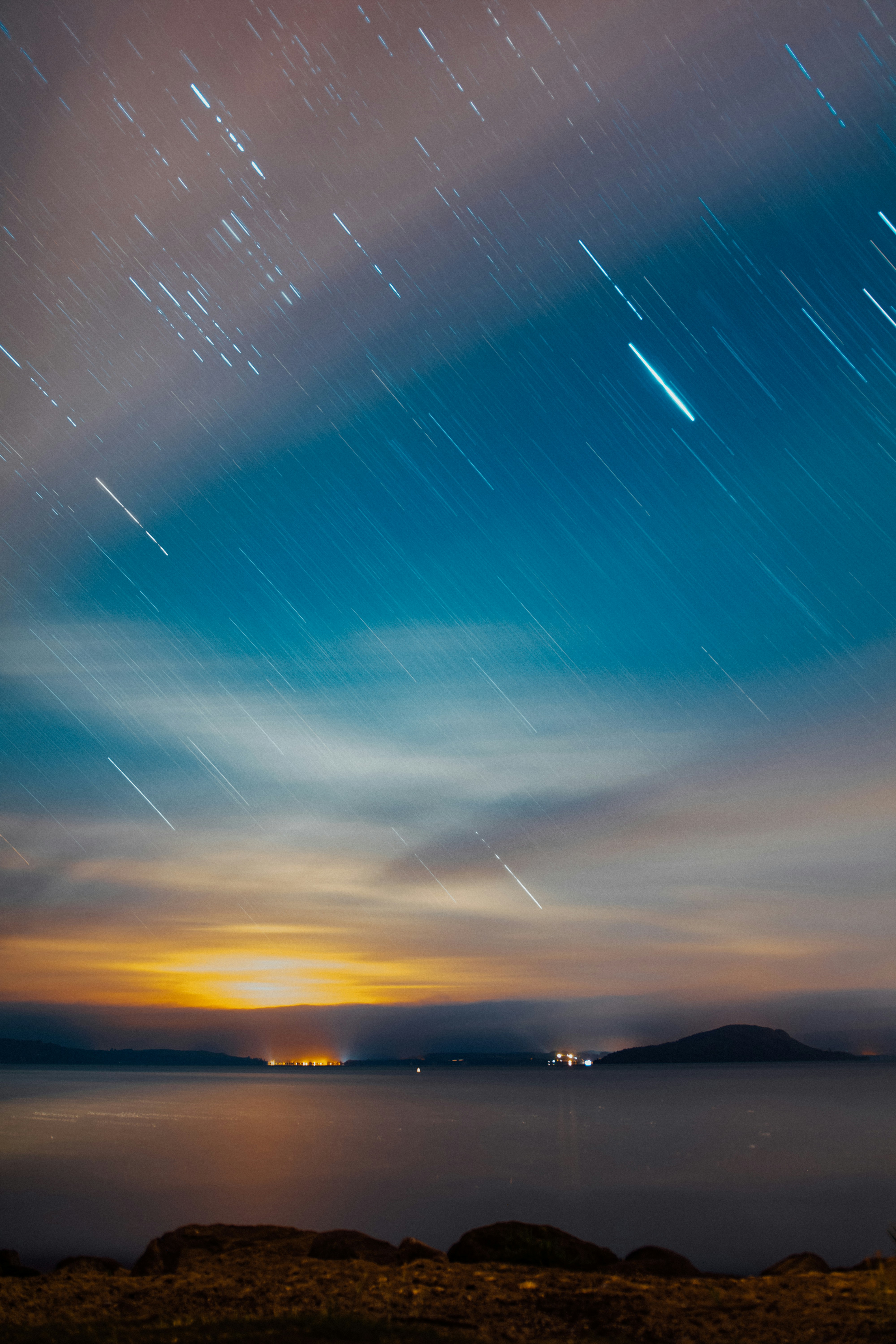Horizon Glow and Star Trails Over a Quiet Coastal Night