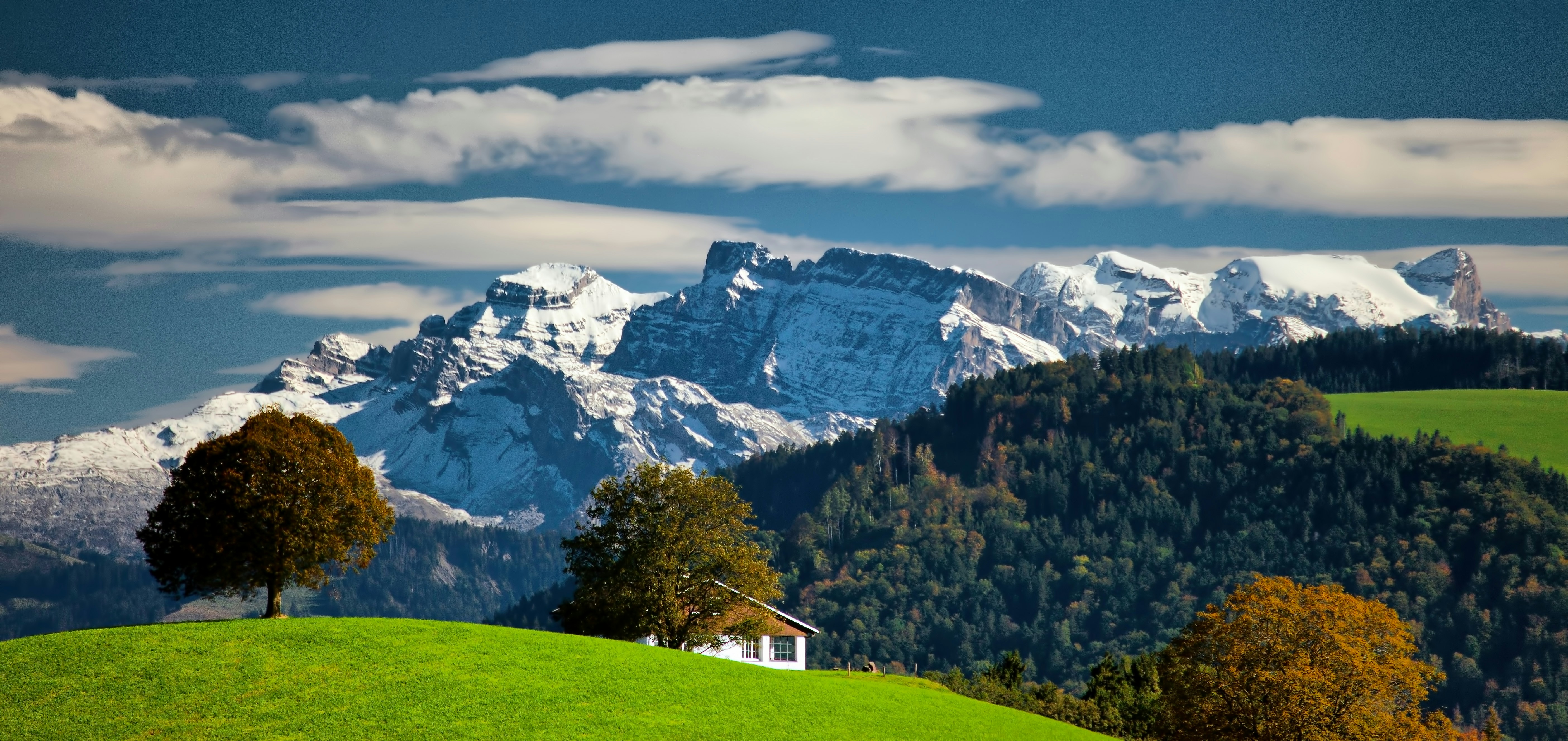 Emerald Hillscape: A Quiet Chalet Beneath Jagged White Peaks