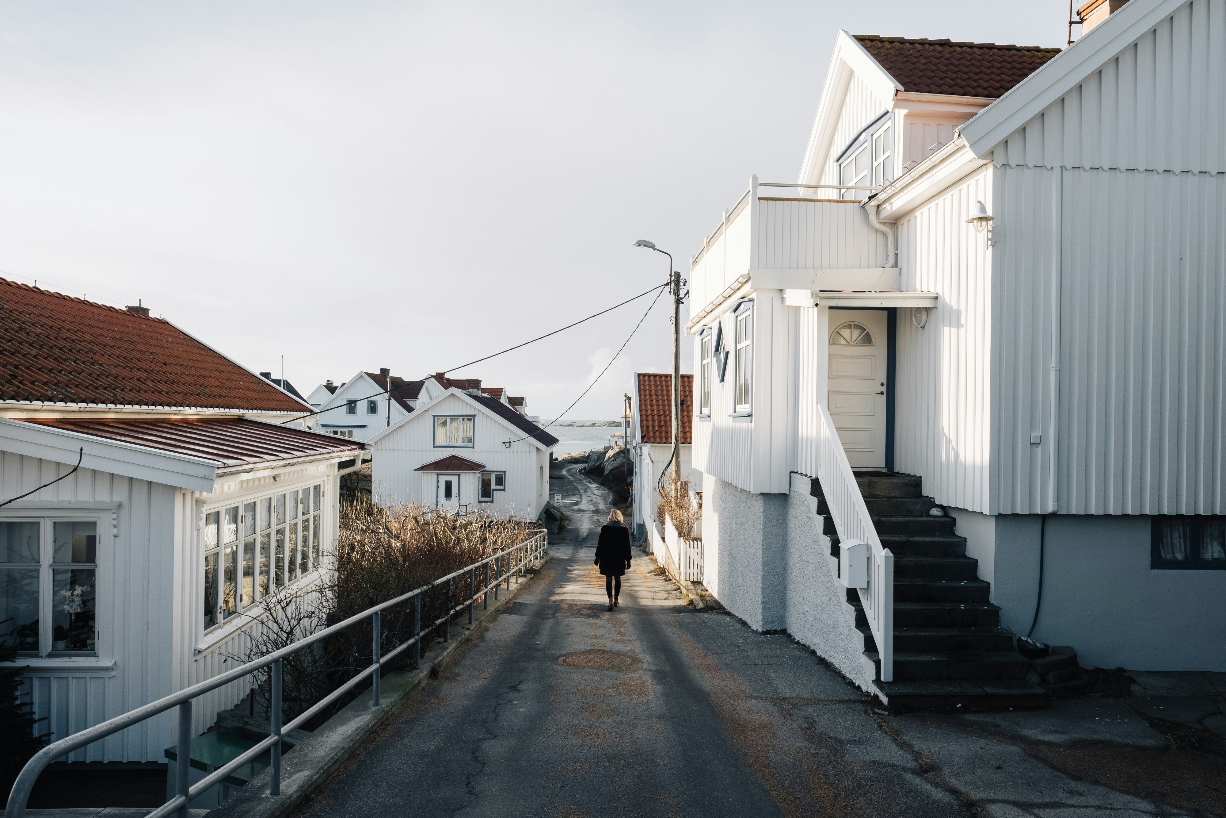 Pathway Through White Wake: A Quiet Street Between Seas of Homes