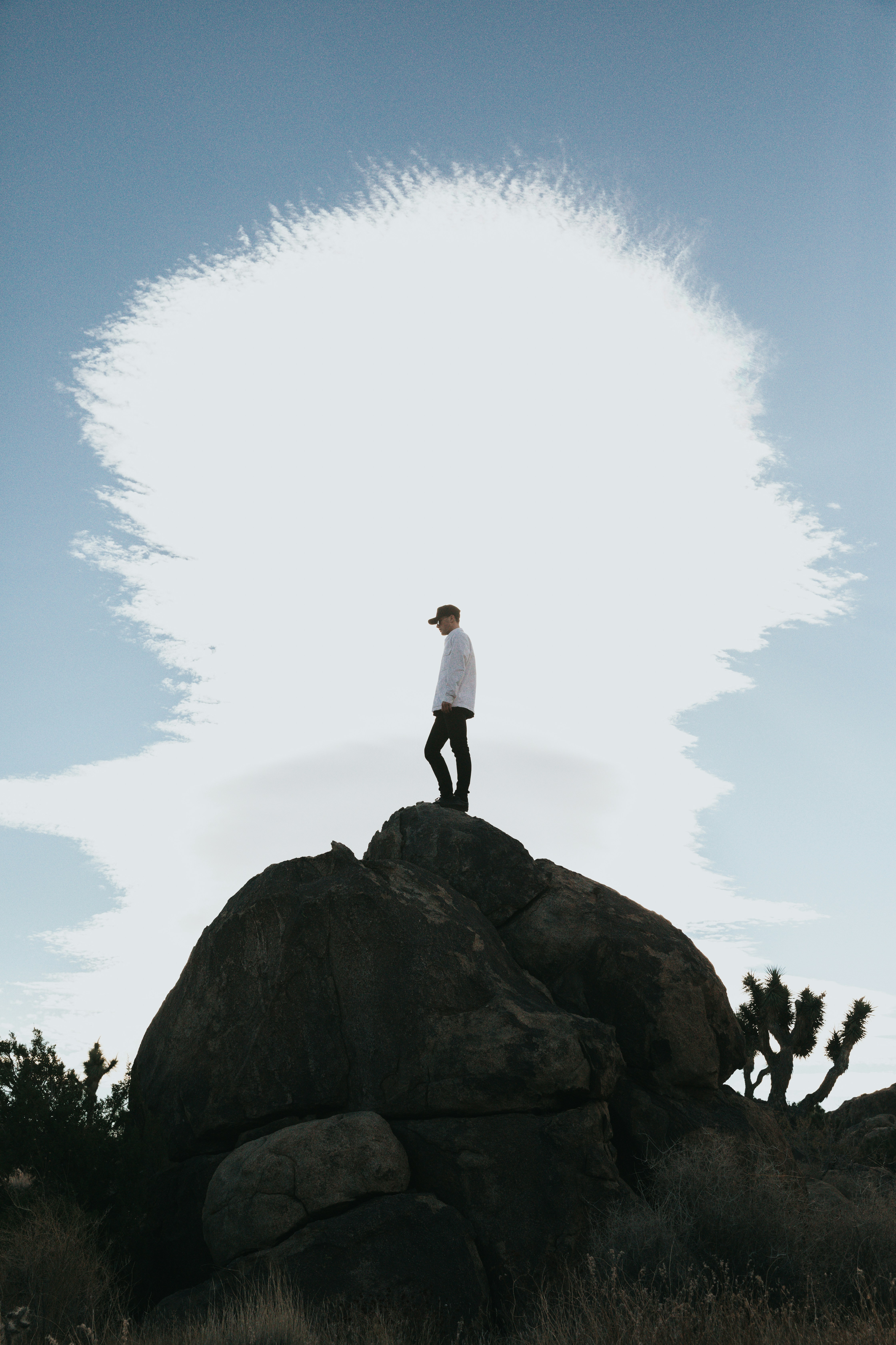 Haloed Summit: A lone climber on weathered granite under a radiant sky