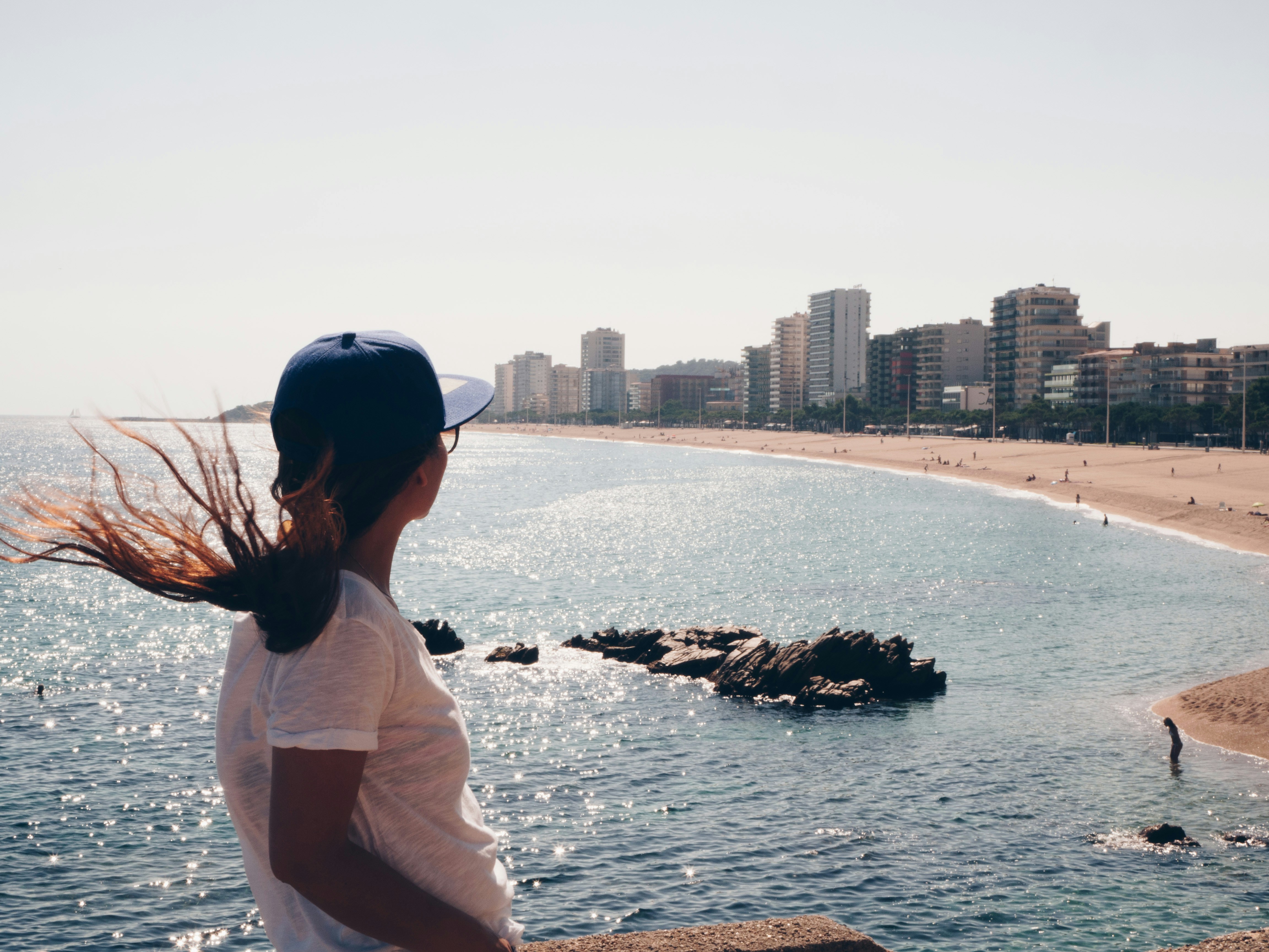 Windward Moment: A Woman Overlooking a Sunlit Coastal City