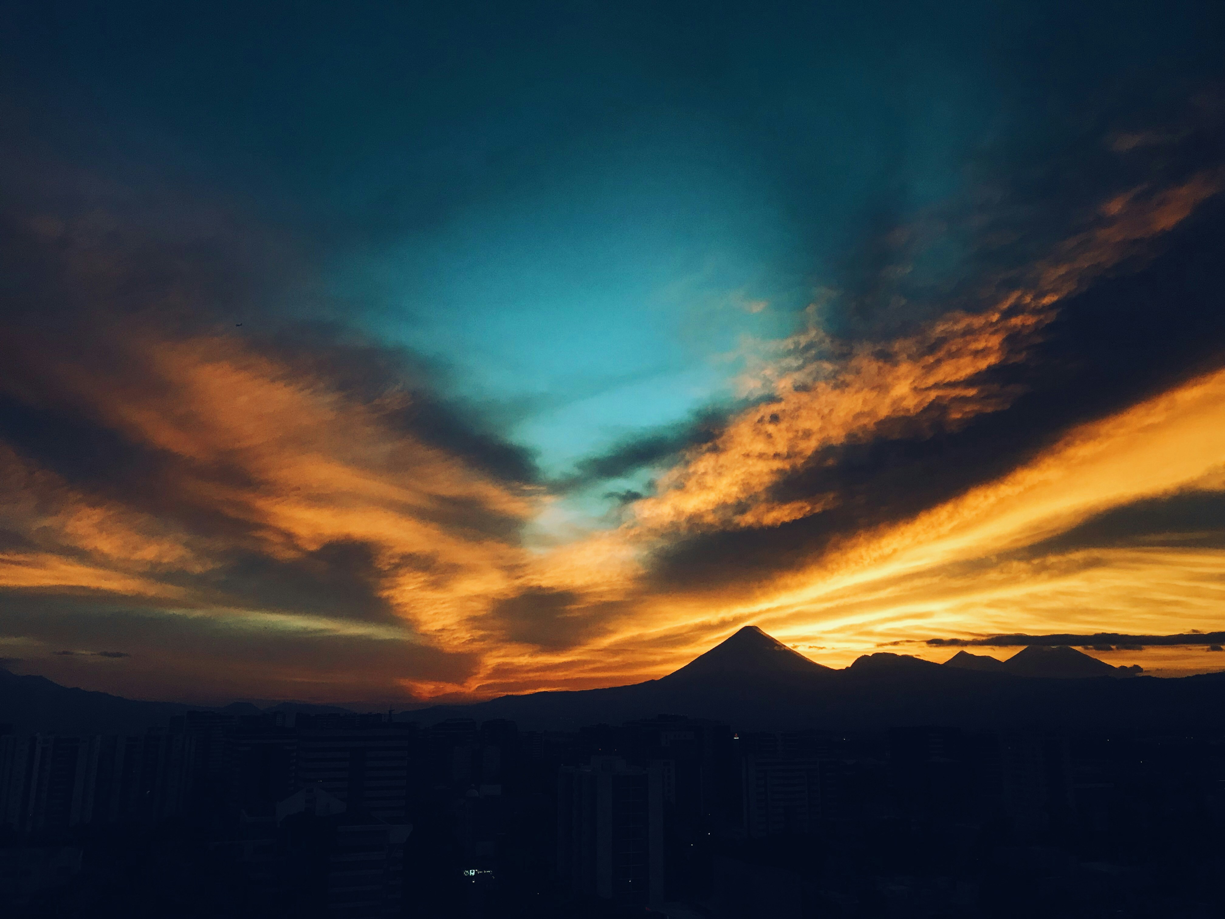 Ember Horizon: City Silhouette Beneath a Turquoise Sunset