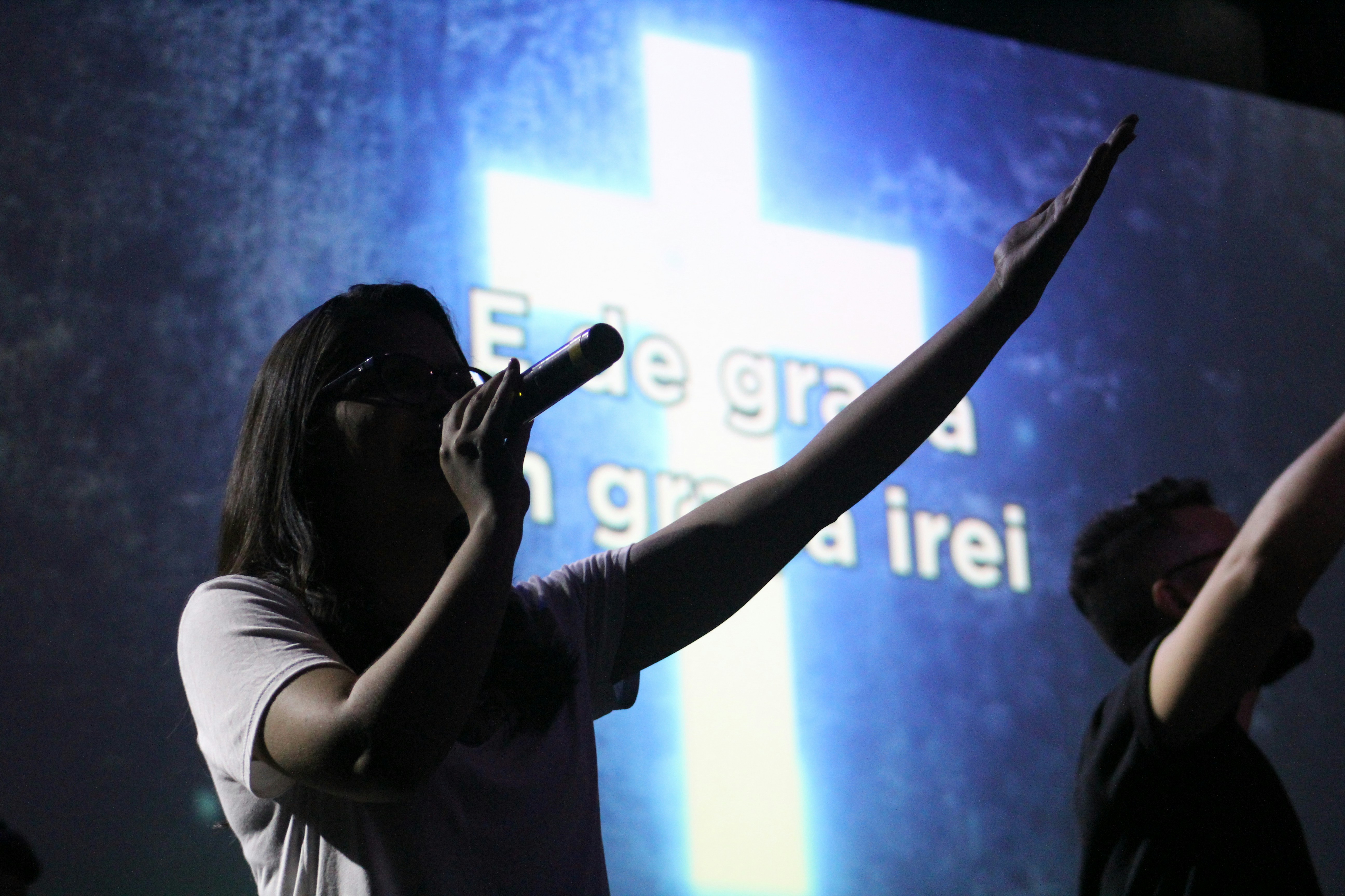 Person holding the microphone while raising his hand photo – Free ...