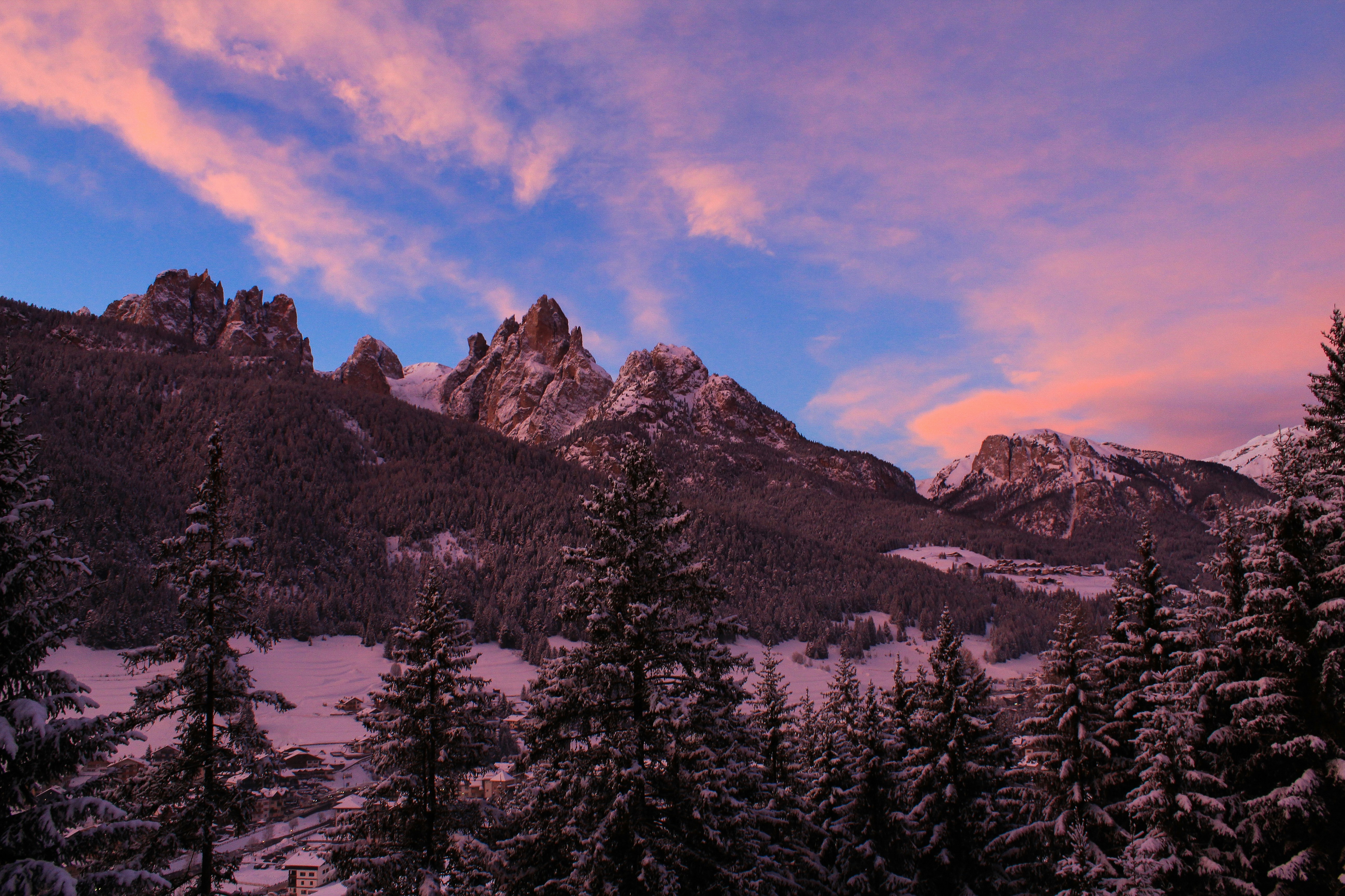 Crimson Ridge at Dusk: Snowy Pines Beneath a Pink-Orange Sky