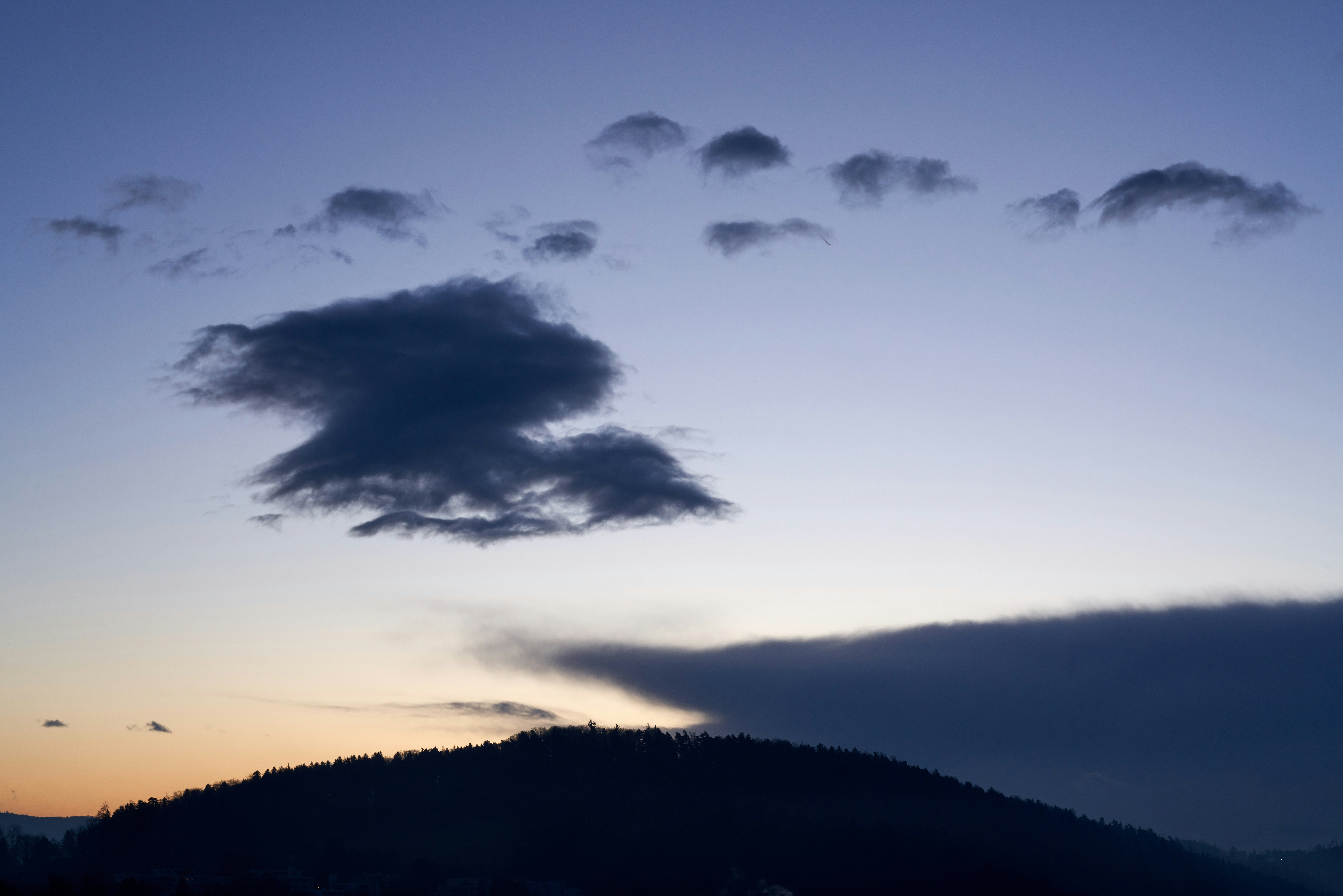 Evening Quiet: A Lone Cloud Drifts Above the Silhouetted Ridge