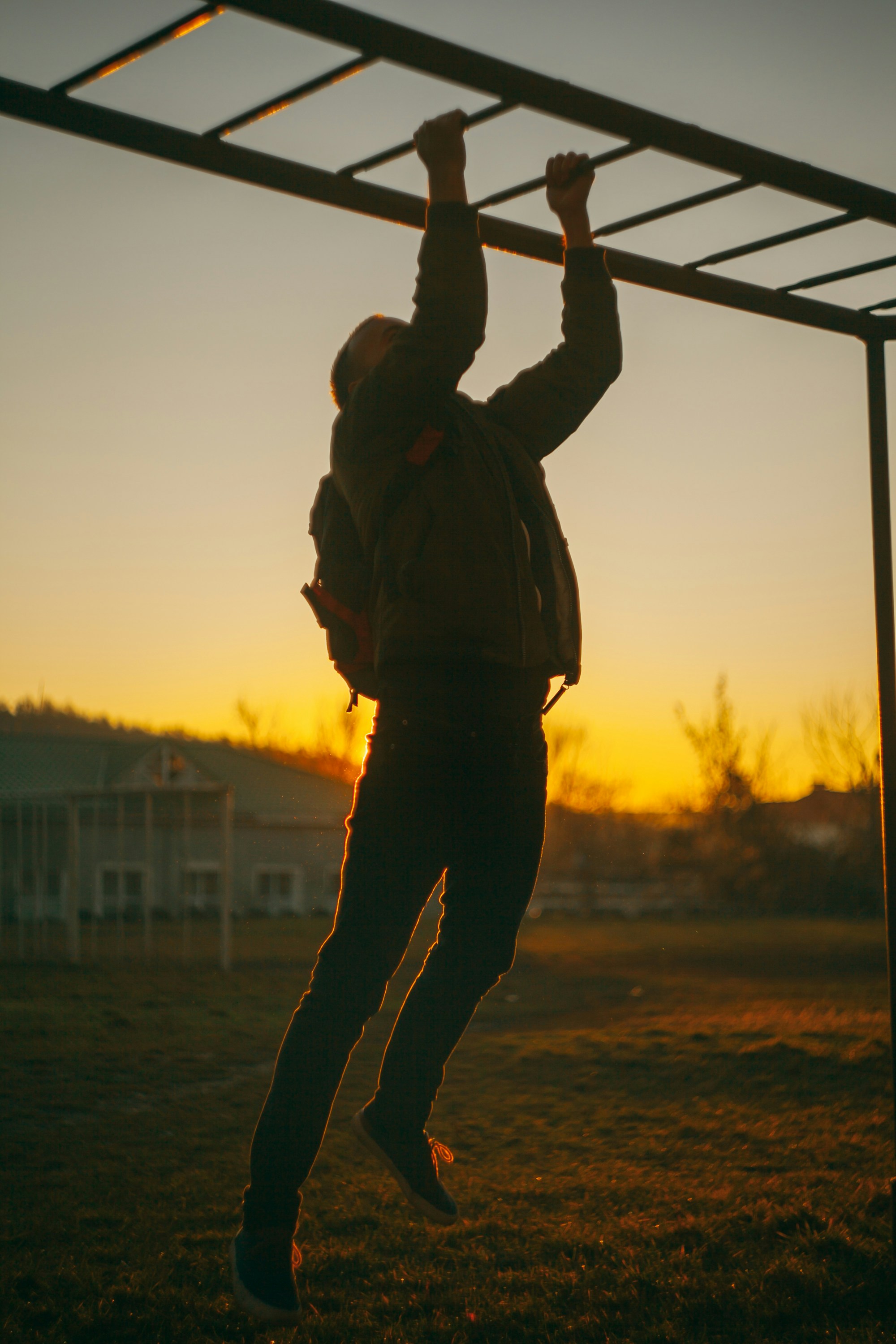 The man is hanging on the pipe.