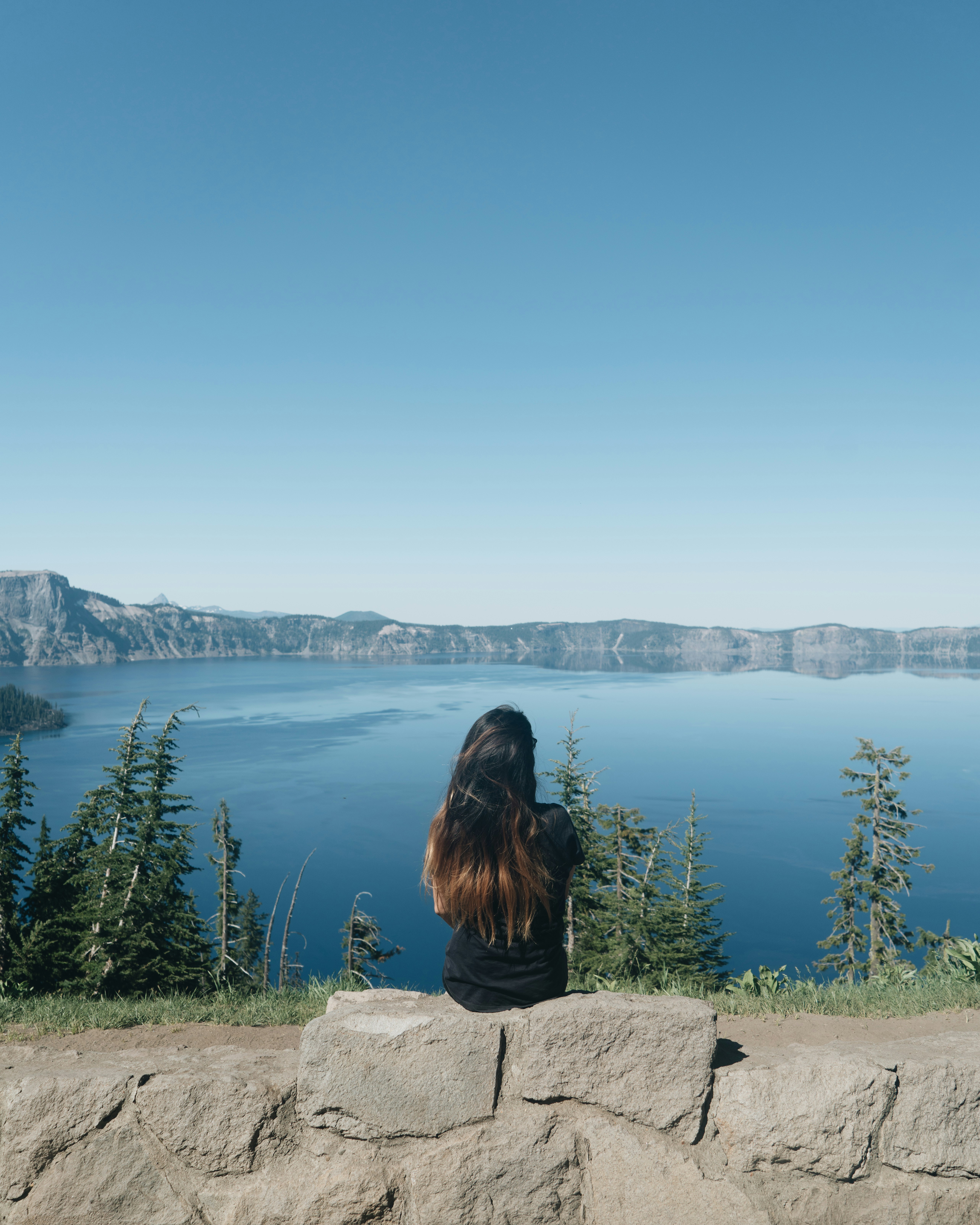 Lone Observer at the Stone Parapet Over a Tranquil Caldera Lake
