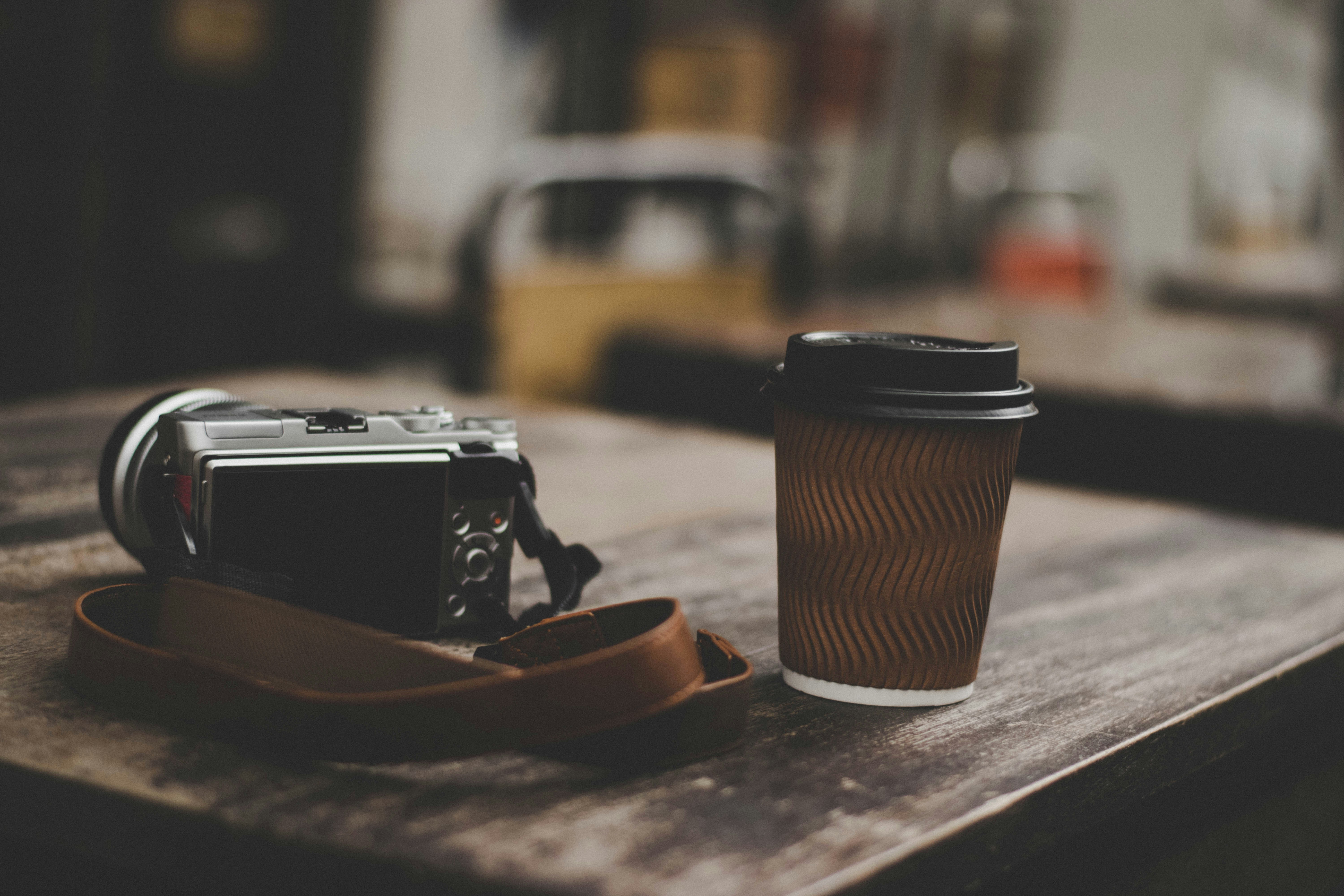 Gray DSLR camera beside brown plastic cup photo – Free Singapore Image ...