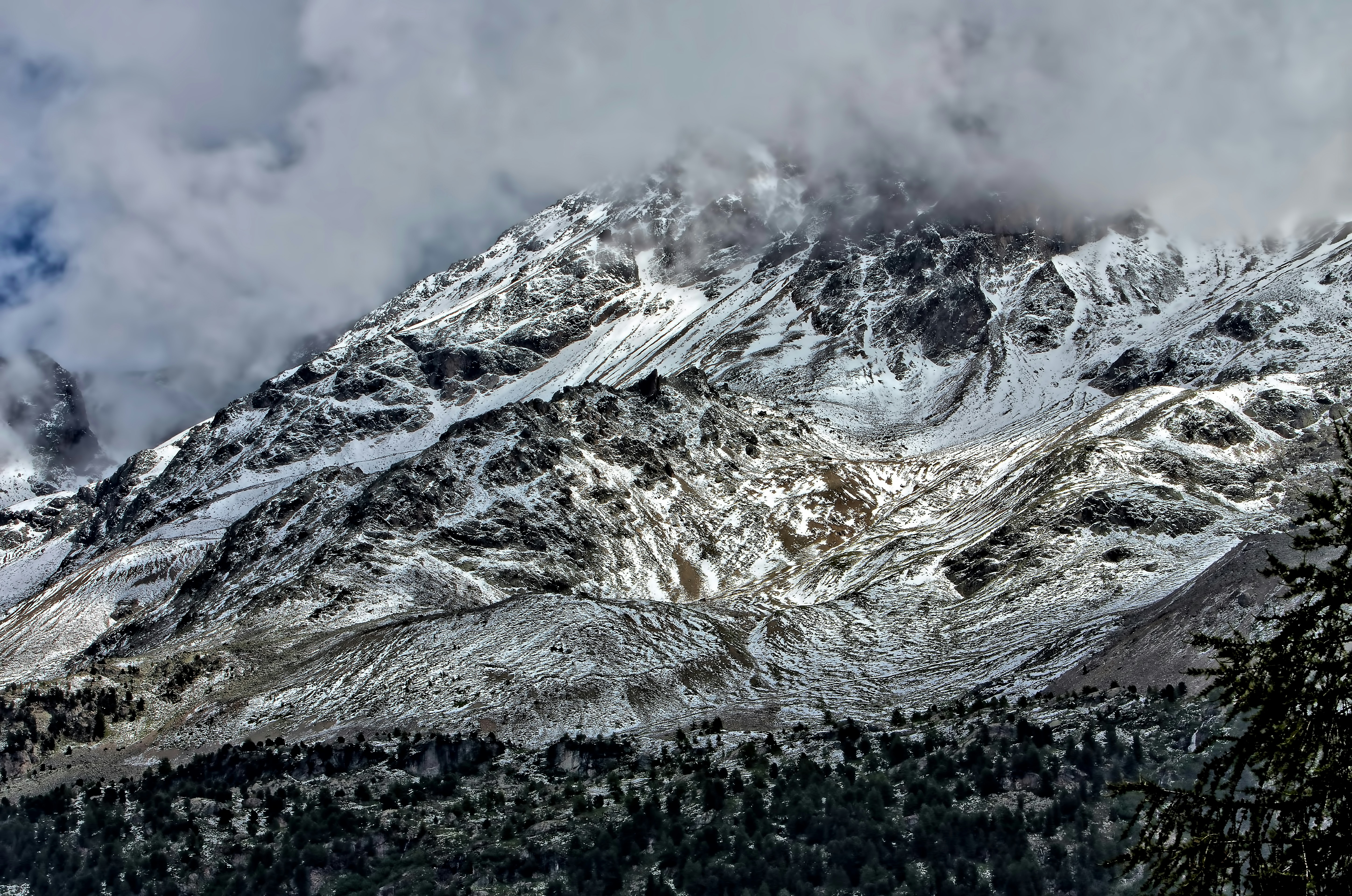Veil of Clouds Over Snowy Peaks