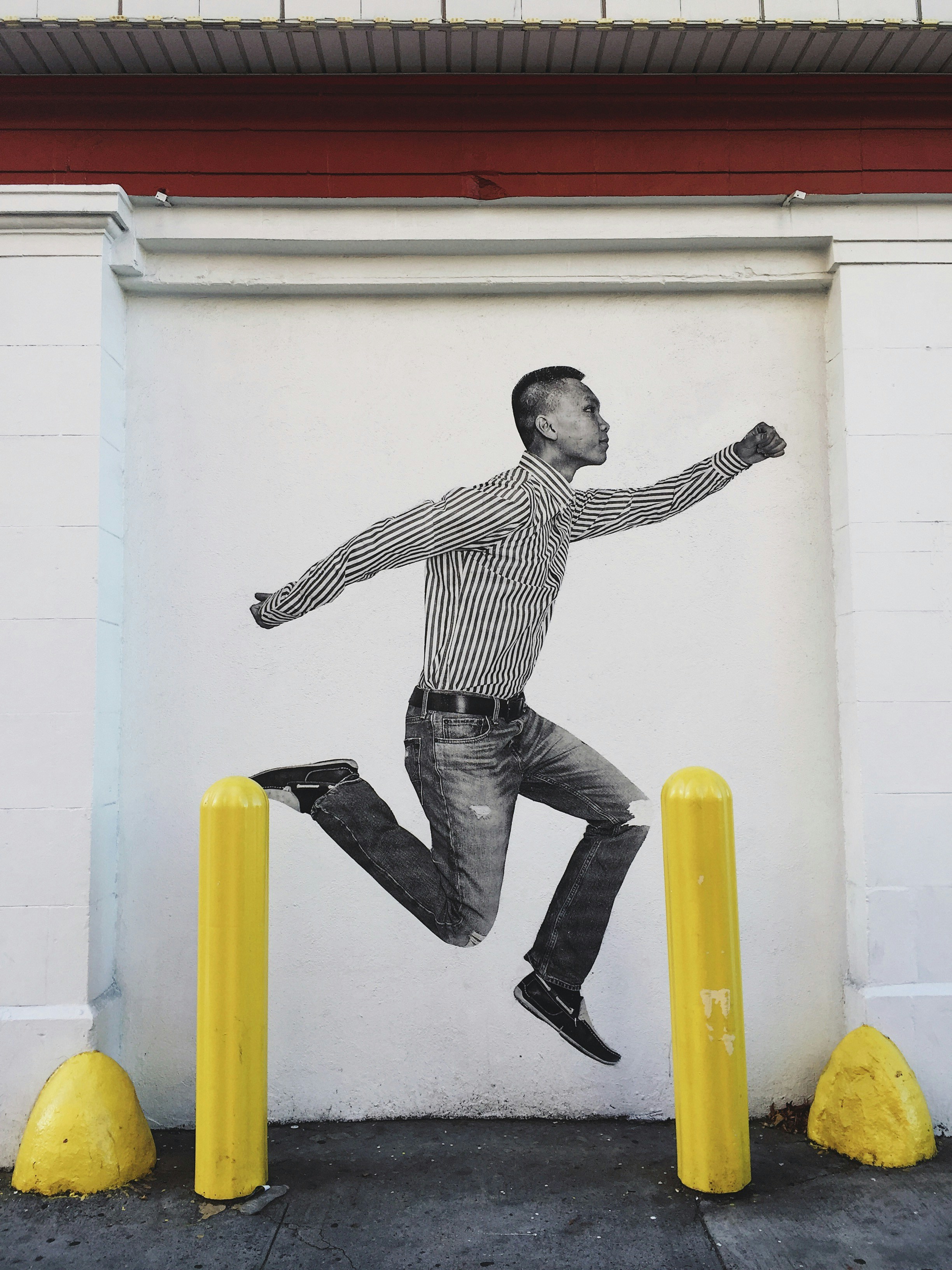 A painting of a man jumping over yellow poles photo – Free Grey Image ...