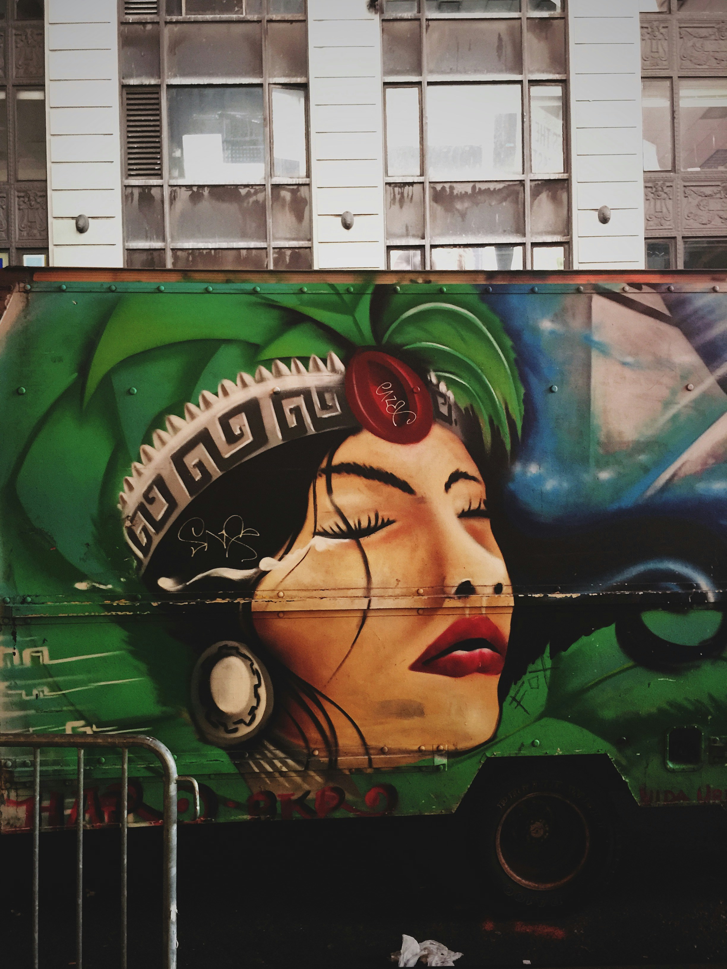 Graffitied Vision: A Woman's Serene Gaze on the Side of a Painted Bus