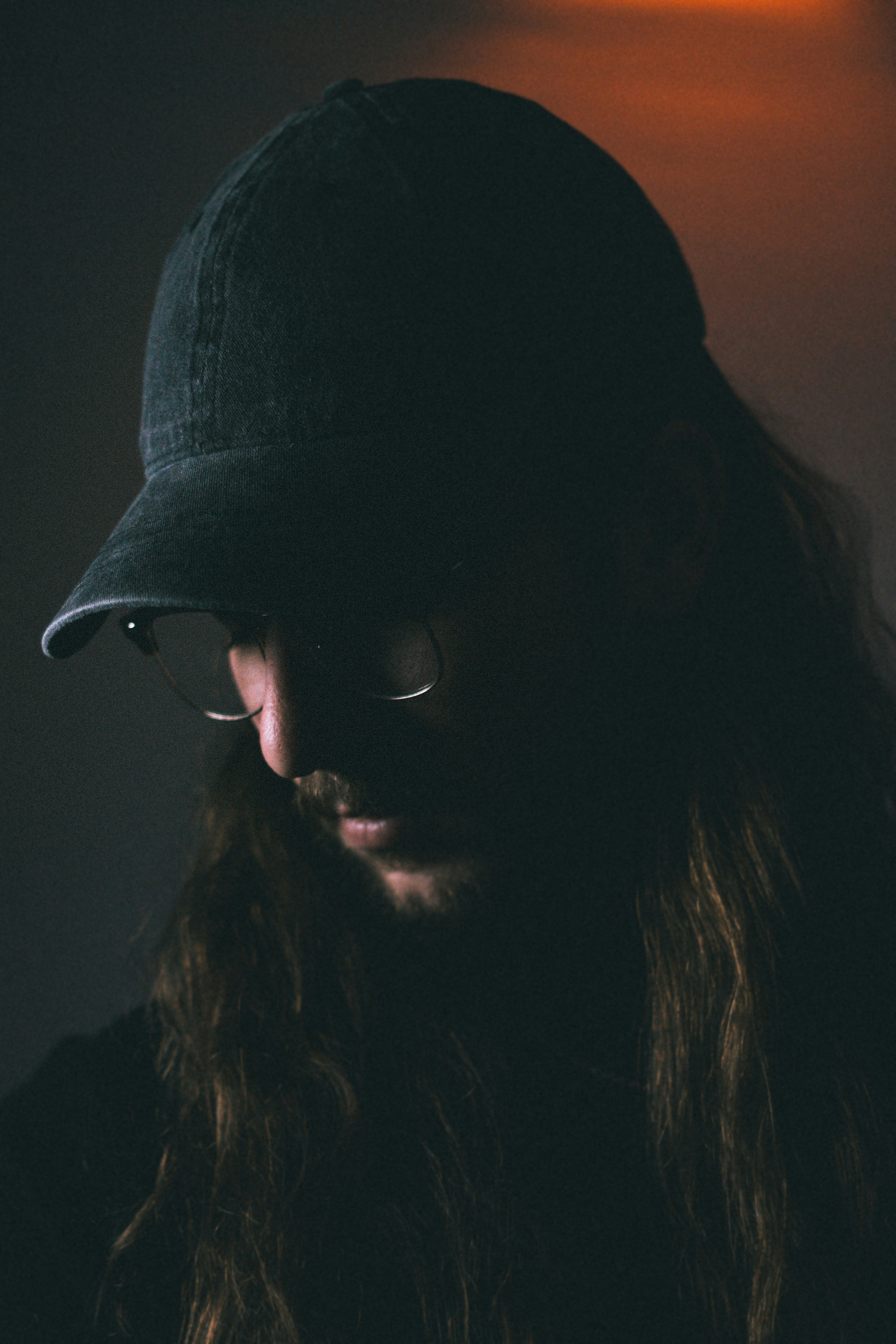 Man wearing black fitted cap looking down closeup photography photo ...