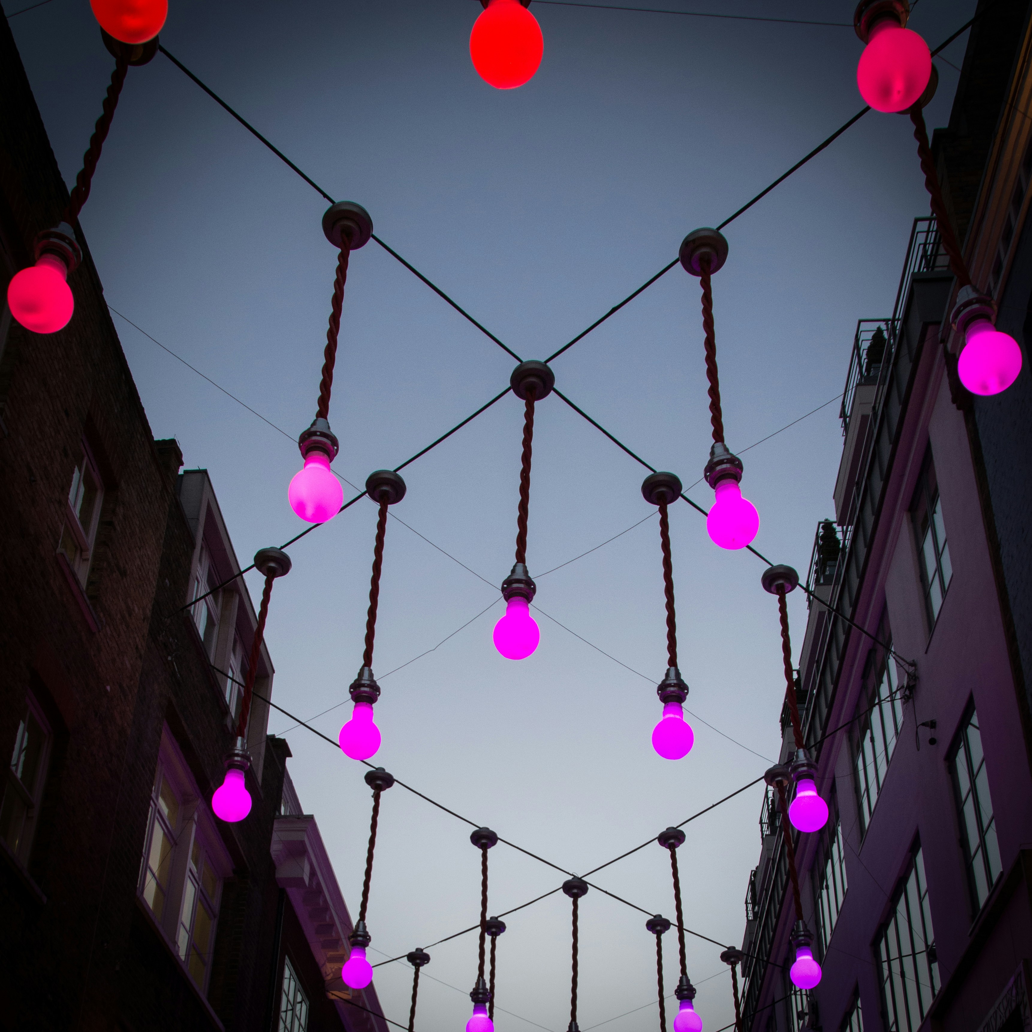 Geometric Neon Lattice Above a Twilight City Street