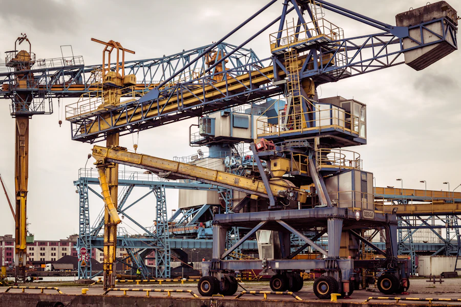 Giant crane and other machinery in sea port and shipyard Gdynia, Poland. | yellow and black tower crane