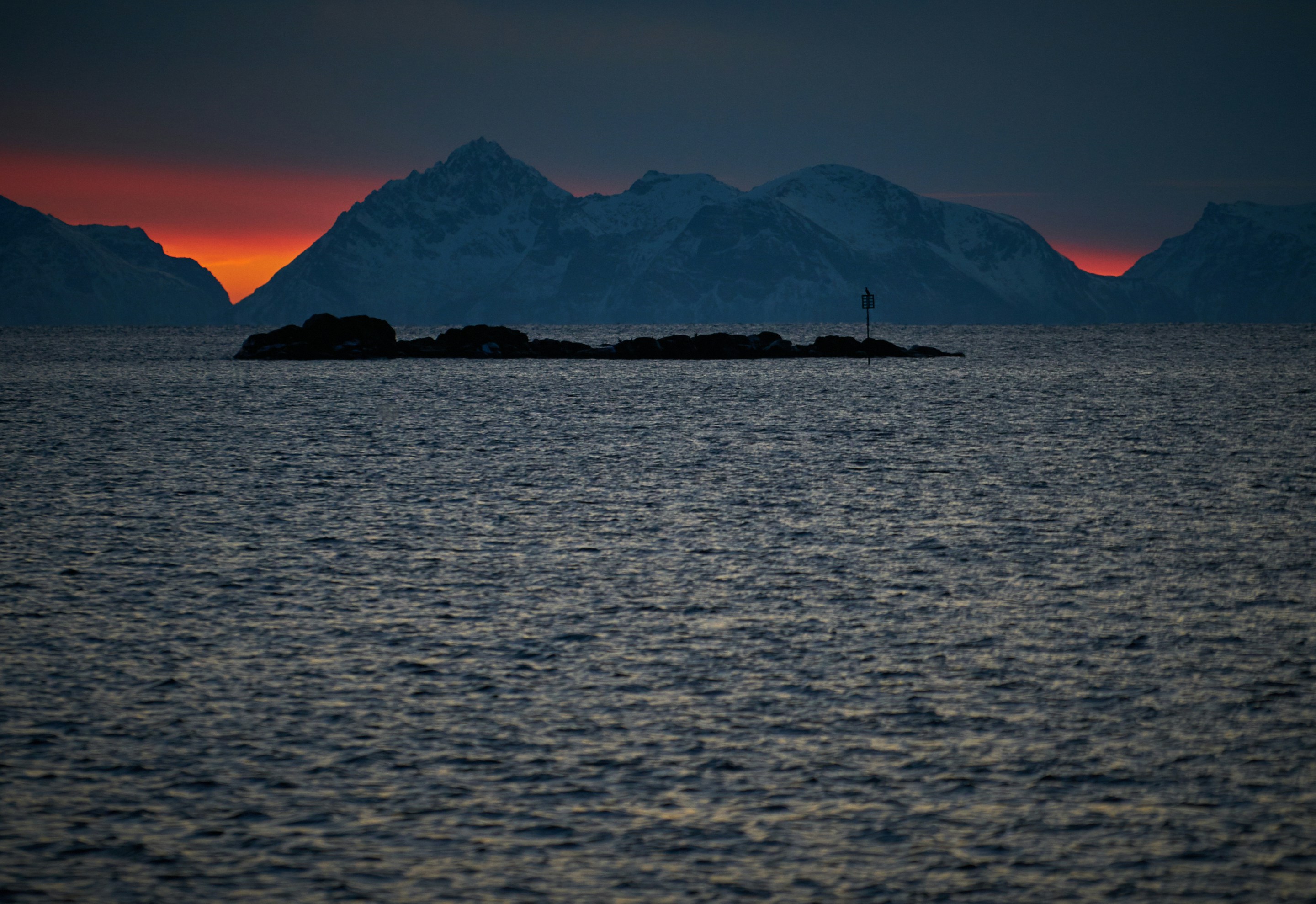 Arctic Dusk: A Quiet Islet Reaching Toward a Crimson Horizon