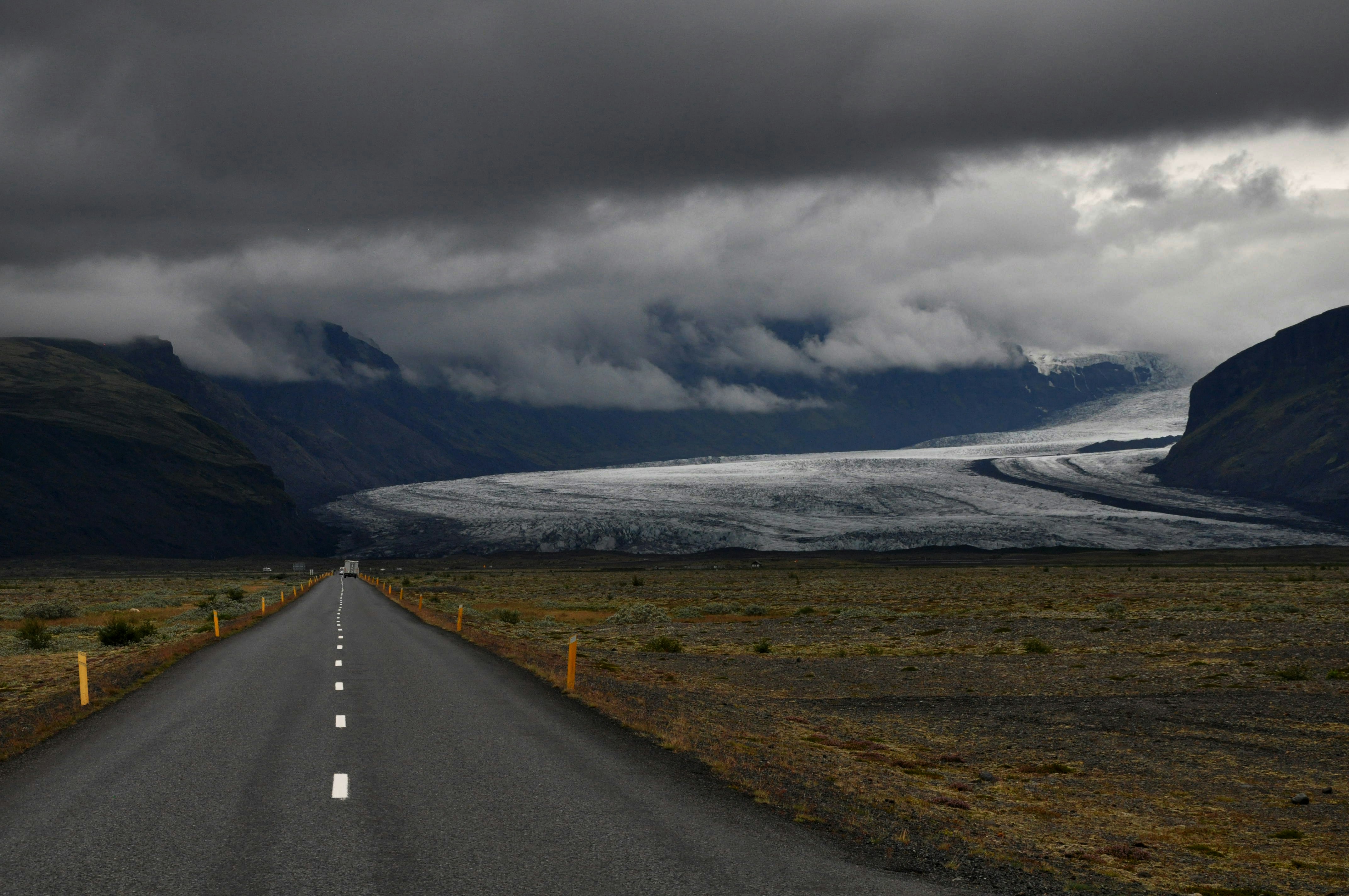 Road to Vatnajökull glacier | grey asphalt road under dark cloudy sky