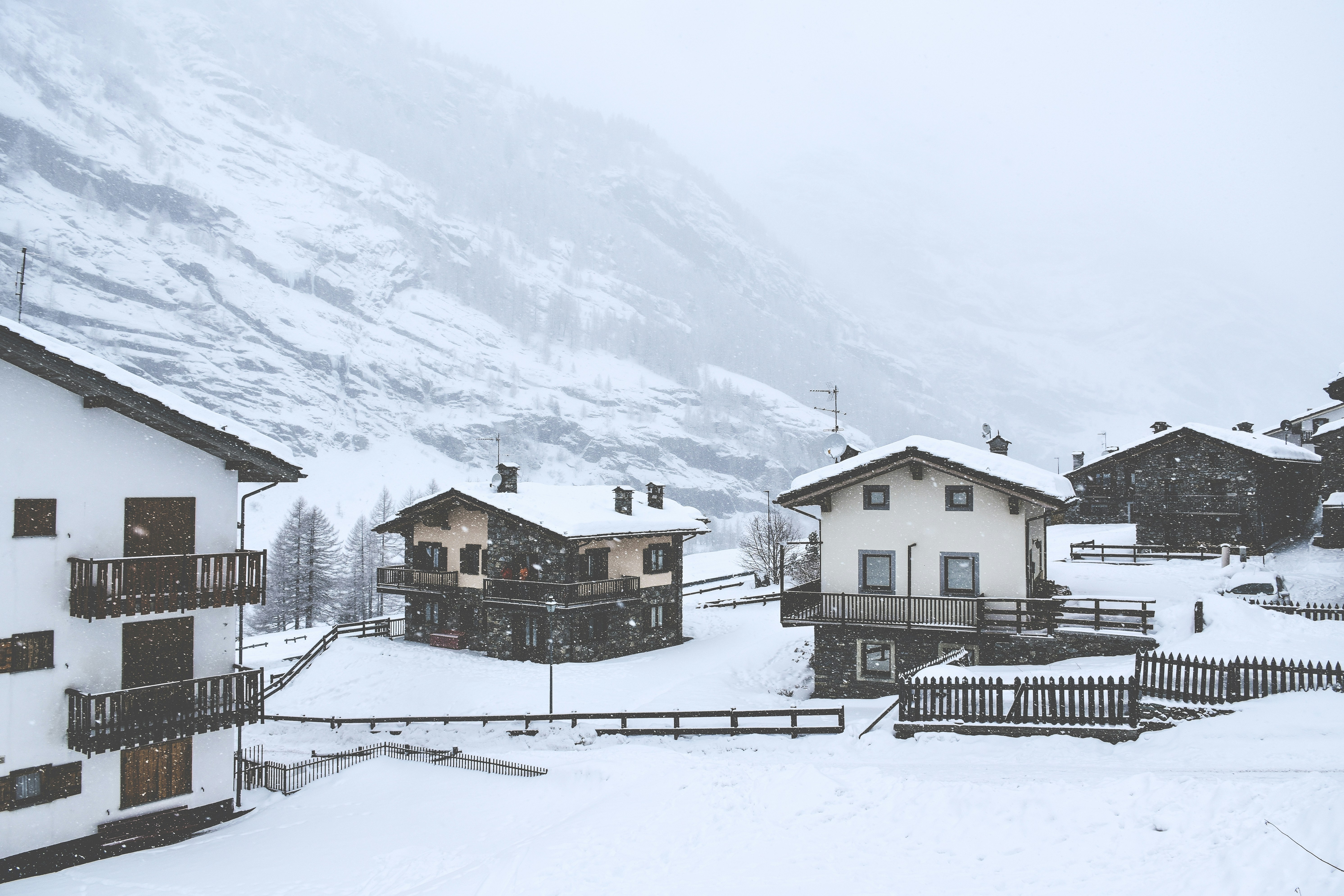 Snow-covered cottages nestled in a serene mountain landscape.
