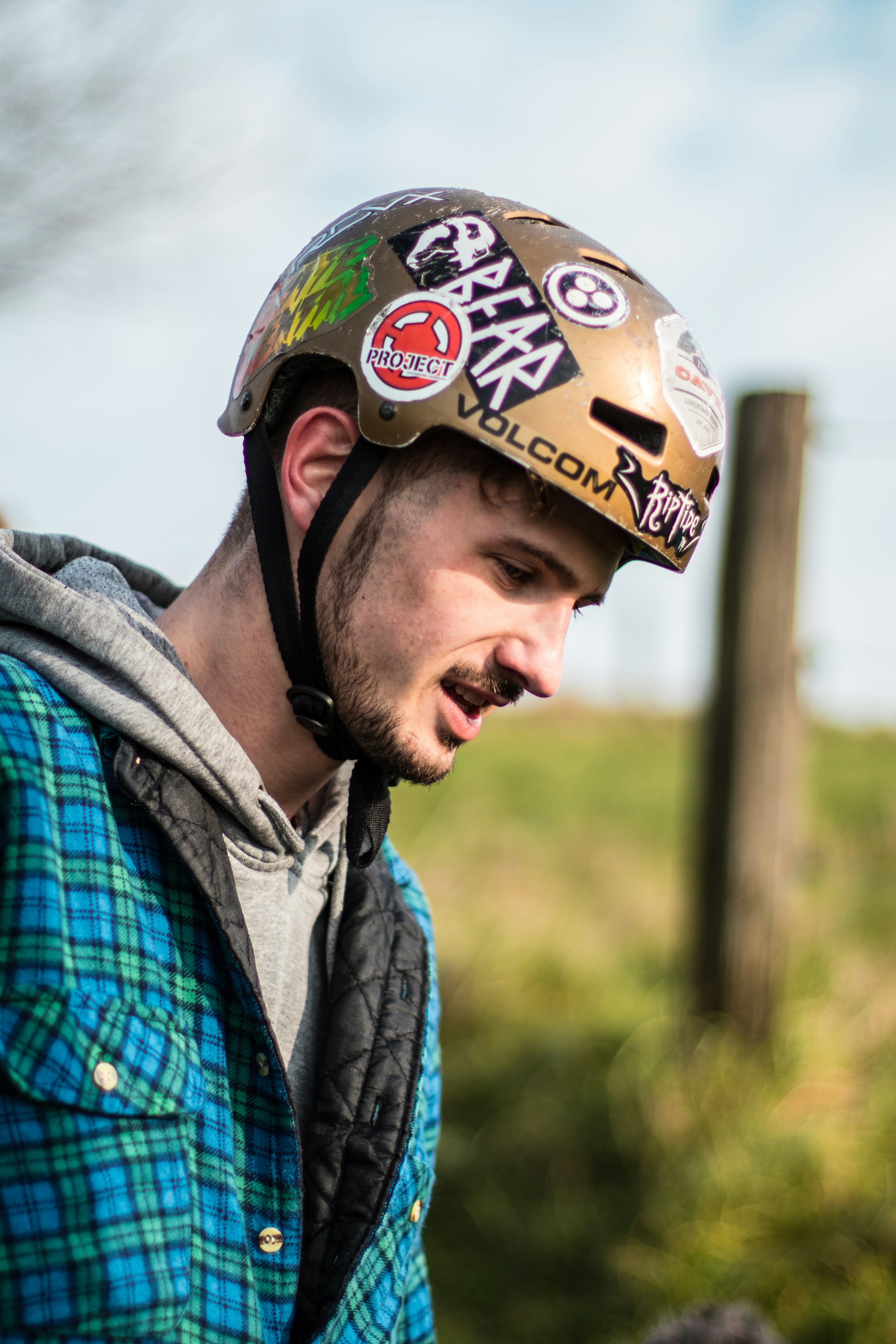 Stickered Helmet Portrait: Quiet Focus in a Sunlit Rural Field