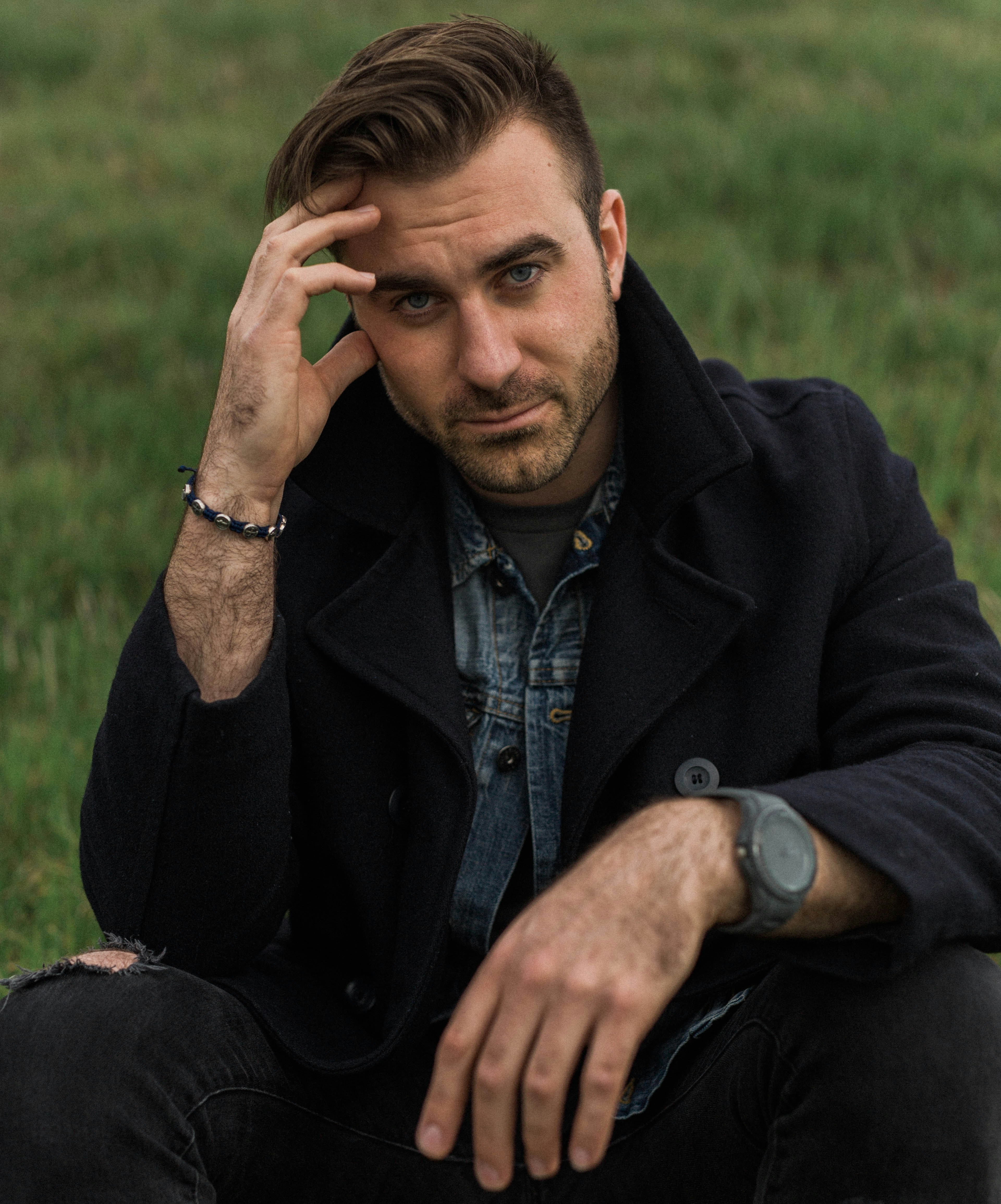 Foto Hombre sosteniendo su cabeza en cuclillas en campo verde – Imagen ...