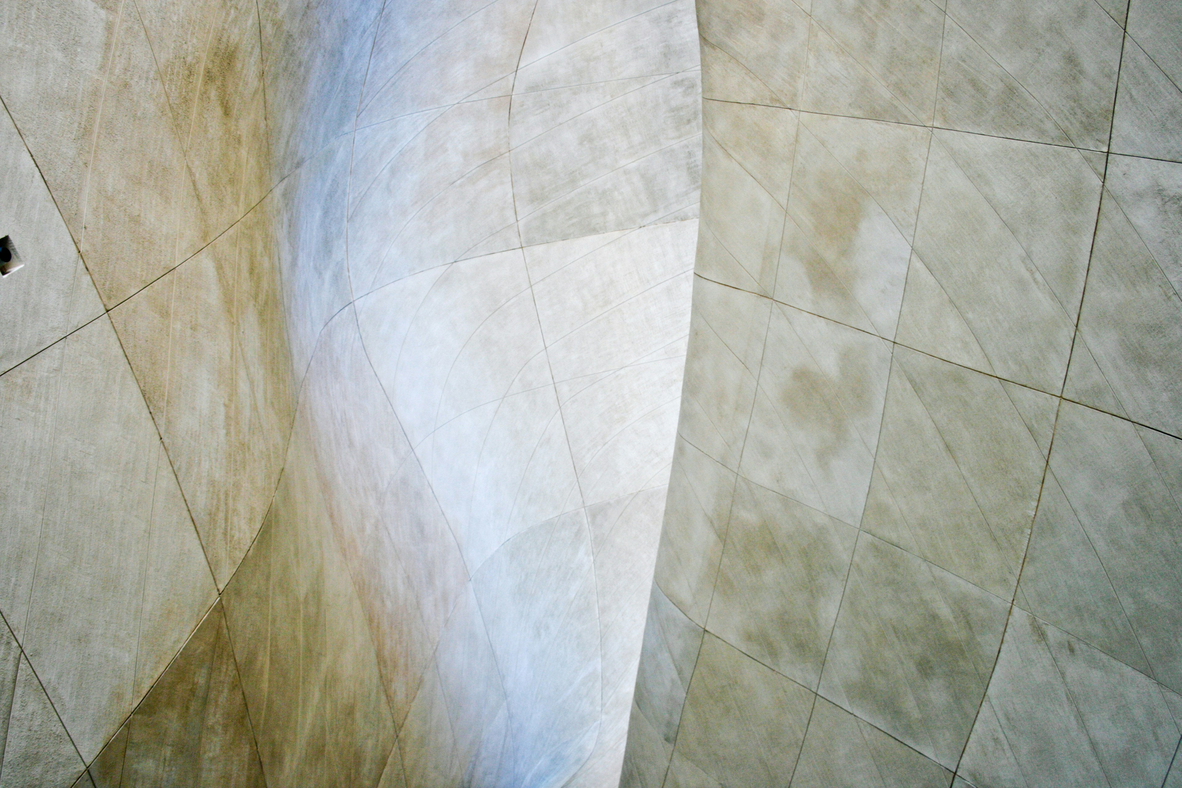 Abstract architecture showcasing smooth, curved surfaces and a play of light across textured walls.