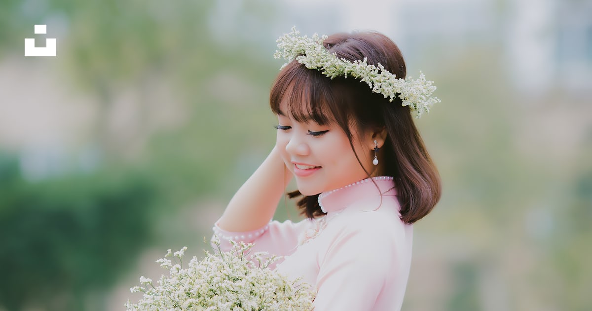 초점 사진에서 흰색 꽃잎이 달린 꽃다발을 들고 머리를 들고 있는 여자 사진 Unsplash의 무료 꽃 이미지