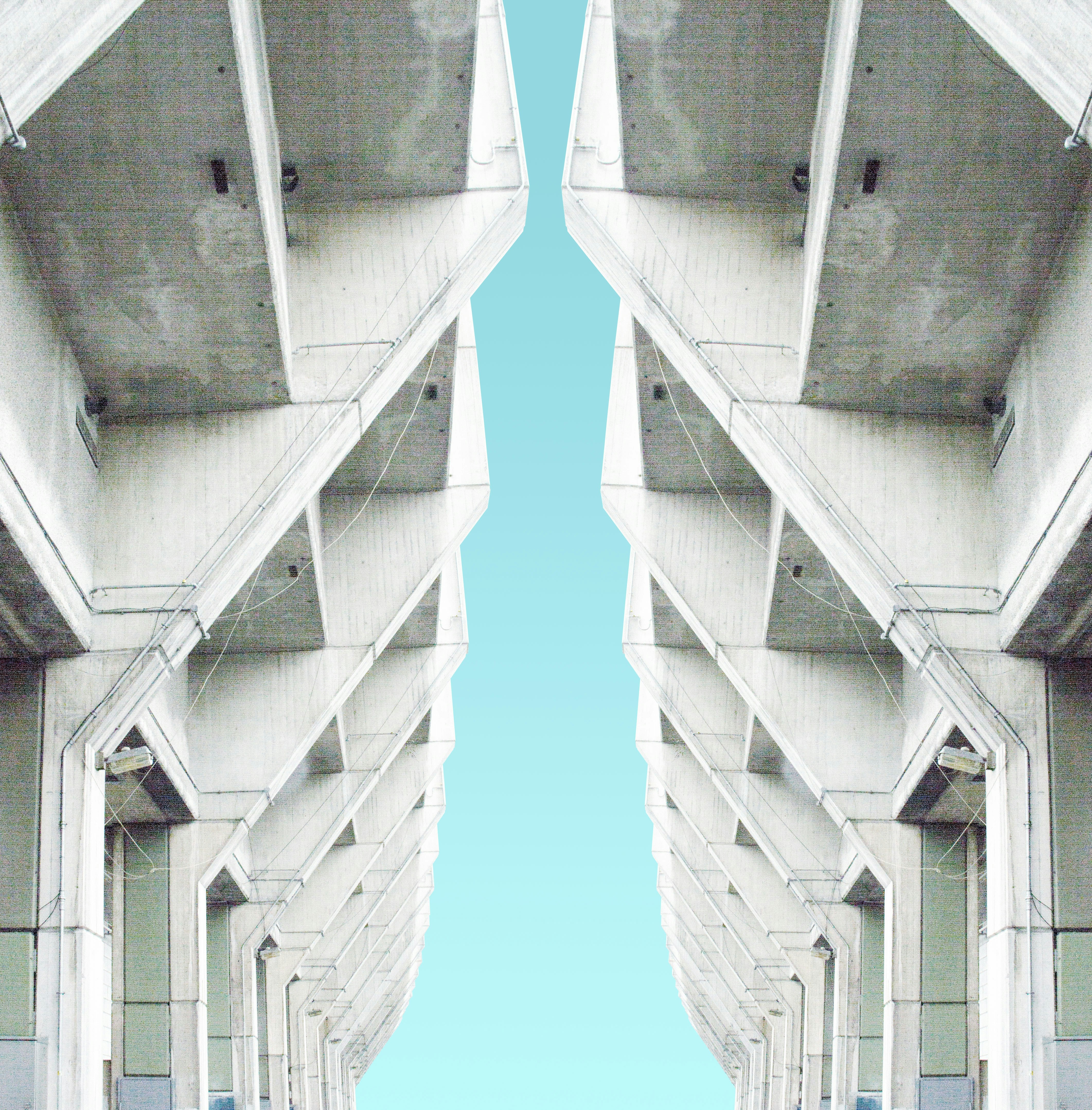 Symmetrical Skyway: Concrete Gap Framing a Pale Blue Horizon